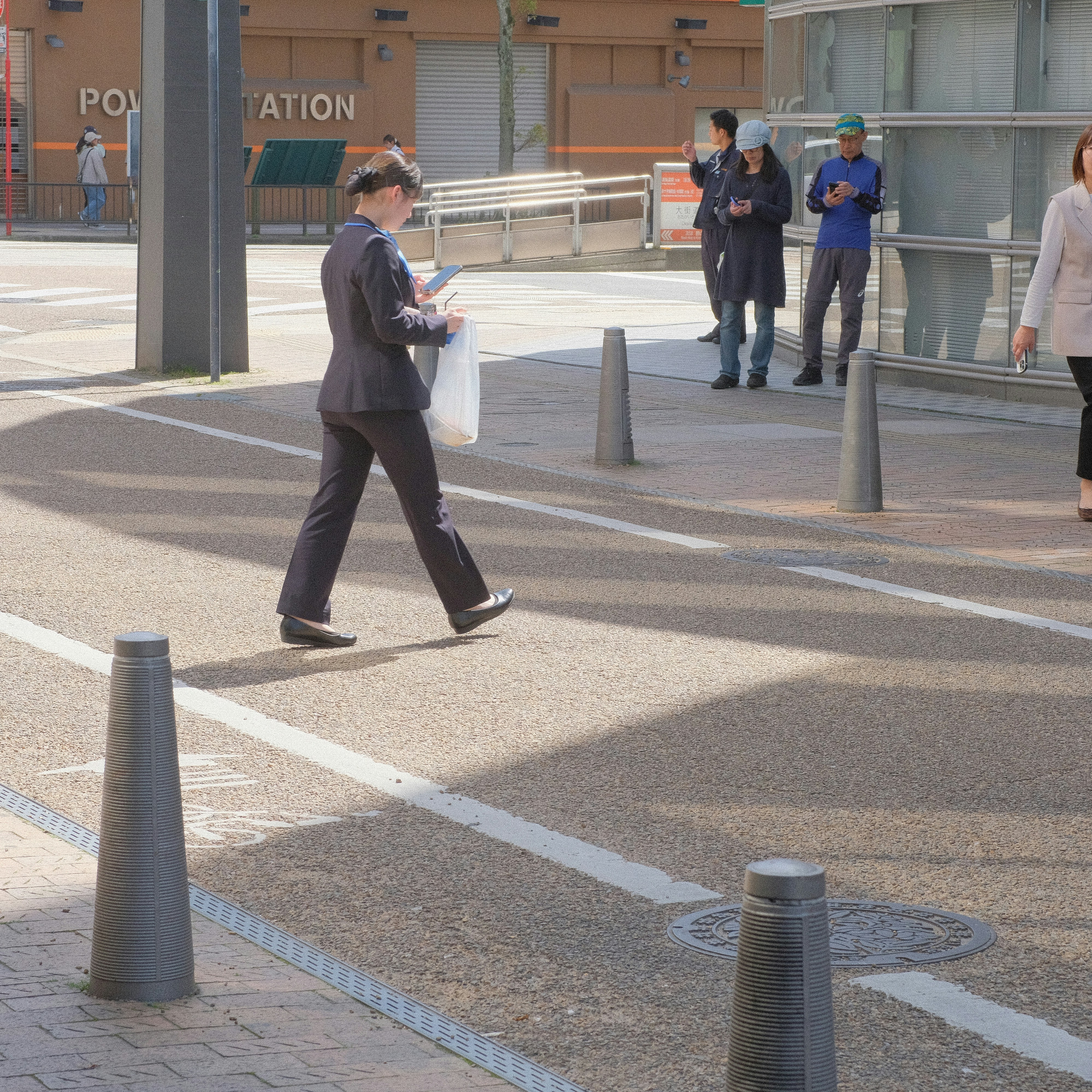 Pedestrian in business attire strode past a transit plaza