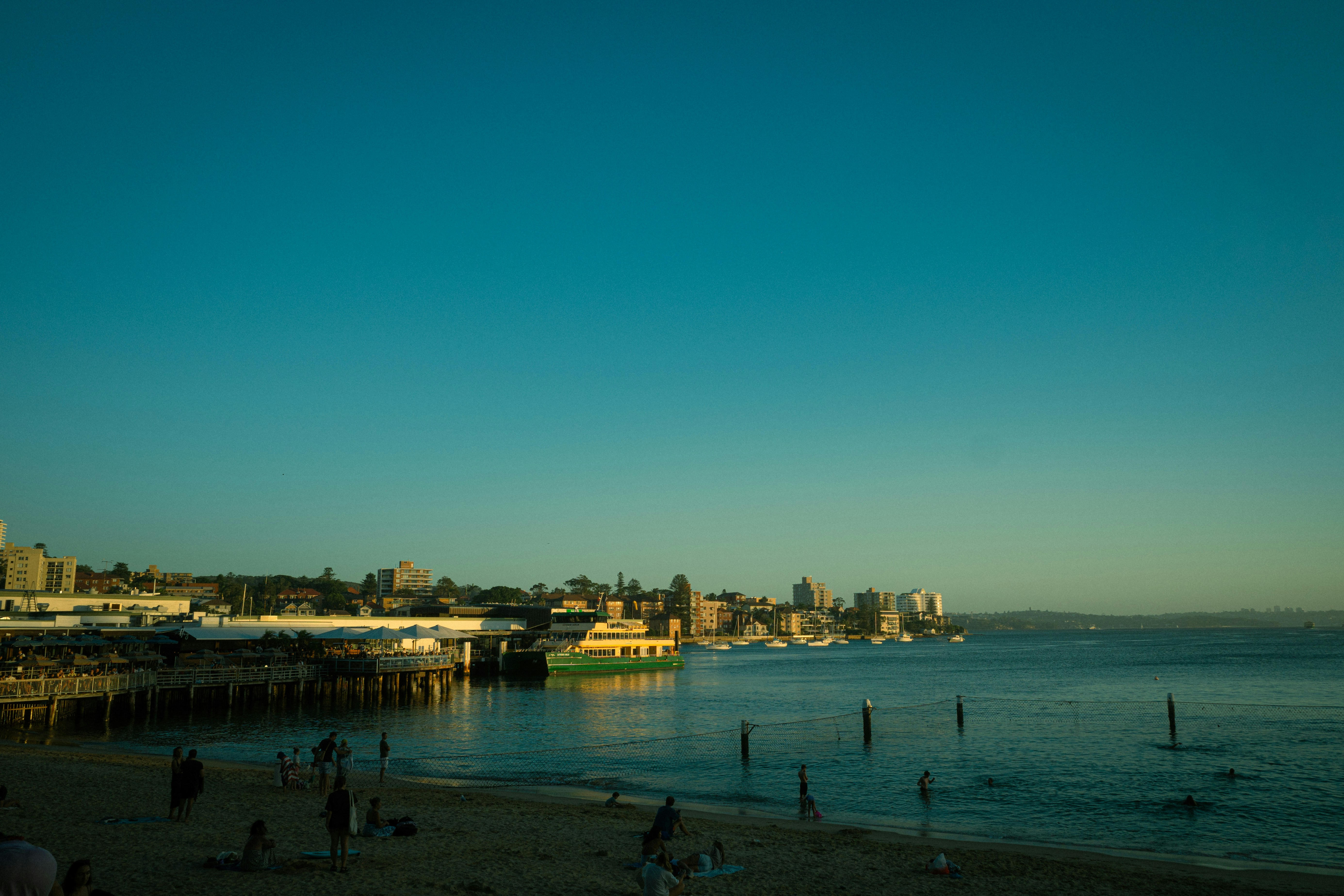 Sunlit Seaside Skyline: People at the Quiet Shore