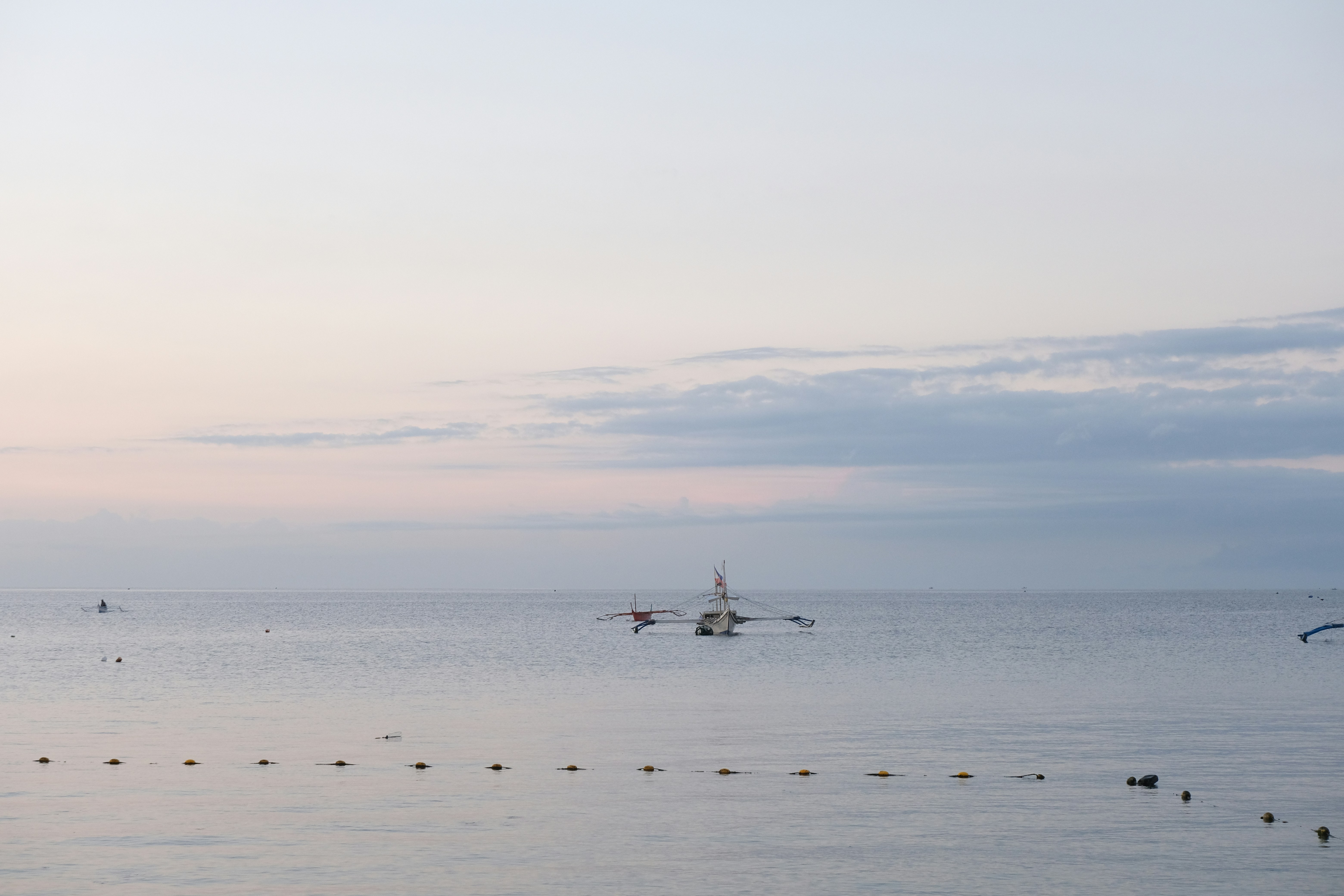 Calm Seascape with Distant Boat Under Soft Sunrise
