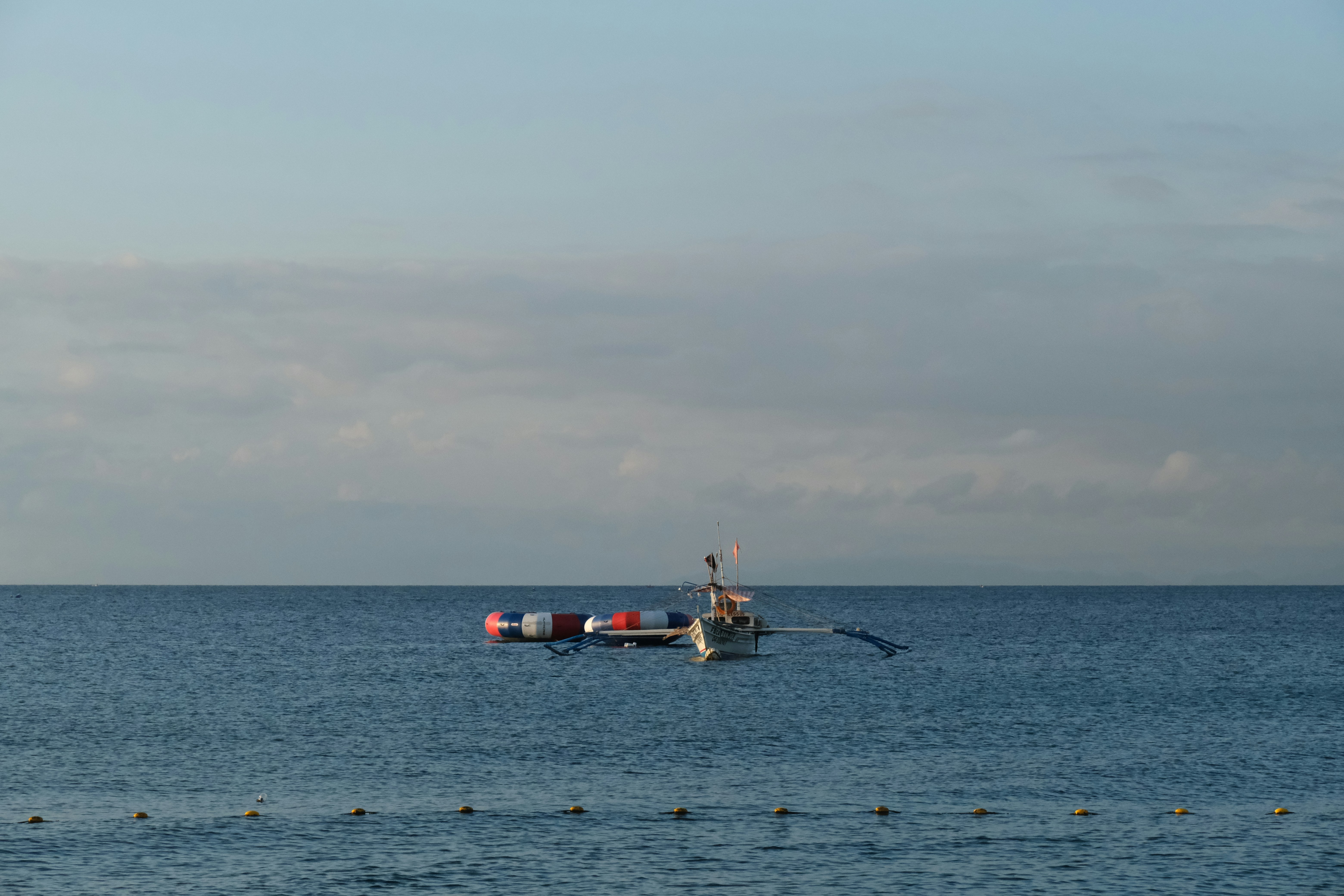 Calm Sea Patrol: A Lone Buoy Boat Stretches Across a Quiet Horizon