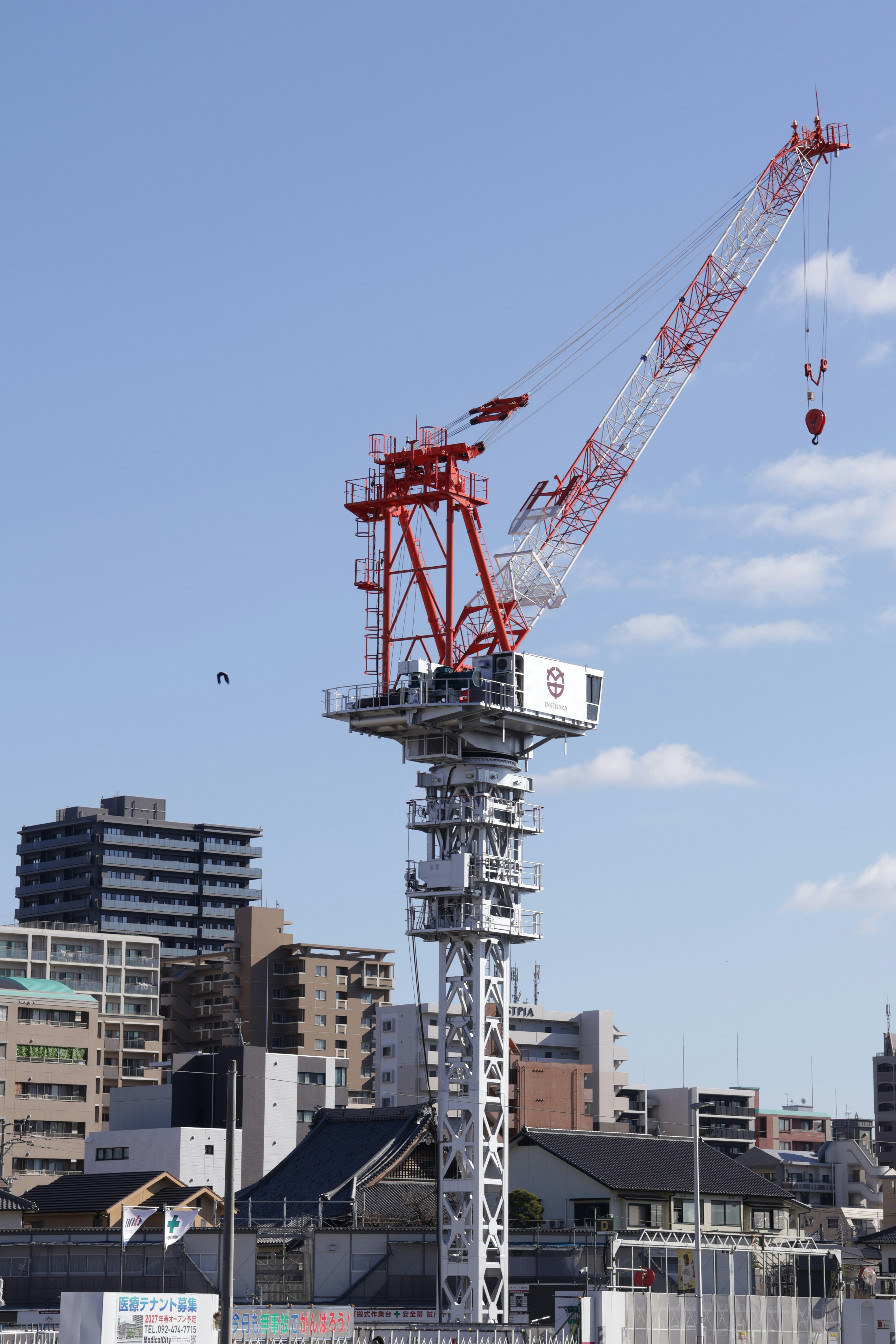 Crane Over the City: A Quiet Skyline Confronts a Towering Red-and-White Lattice