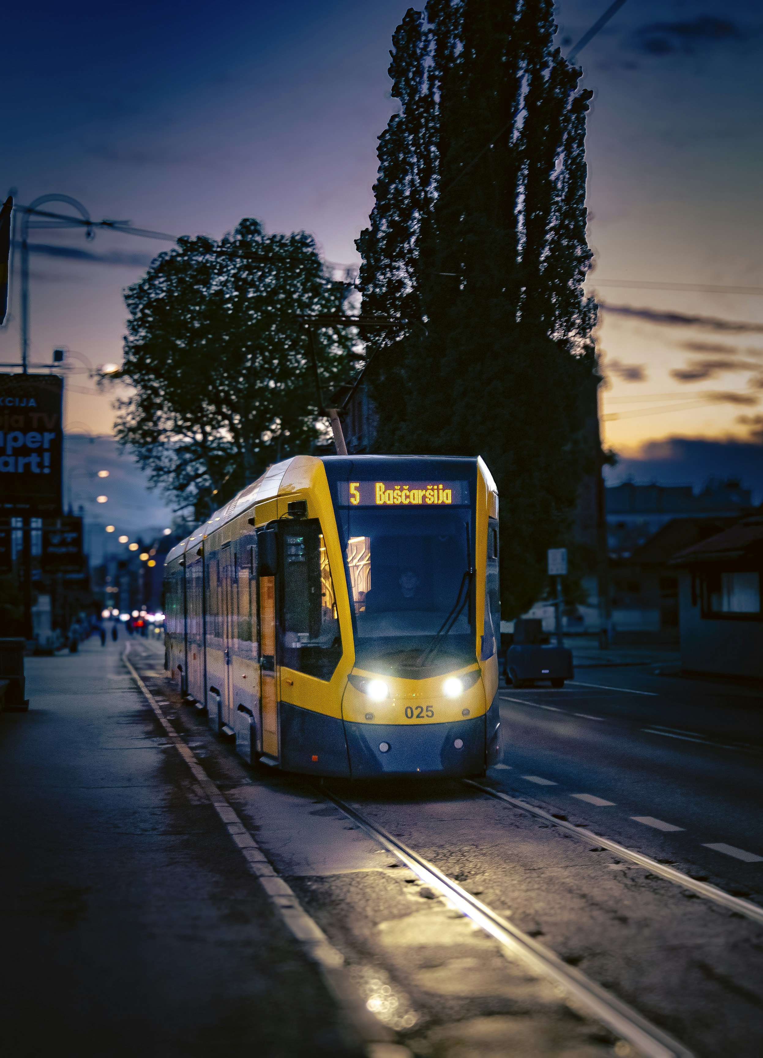 Oncoming City Pulse: Yellow Tram Gliding Through Evening Streets