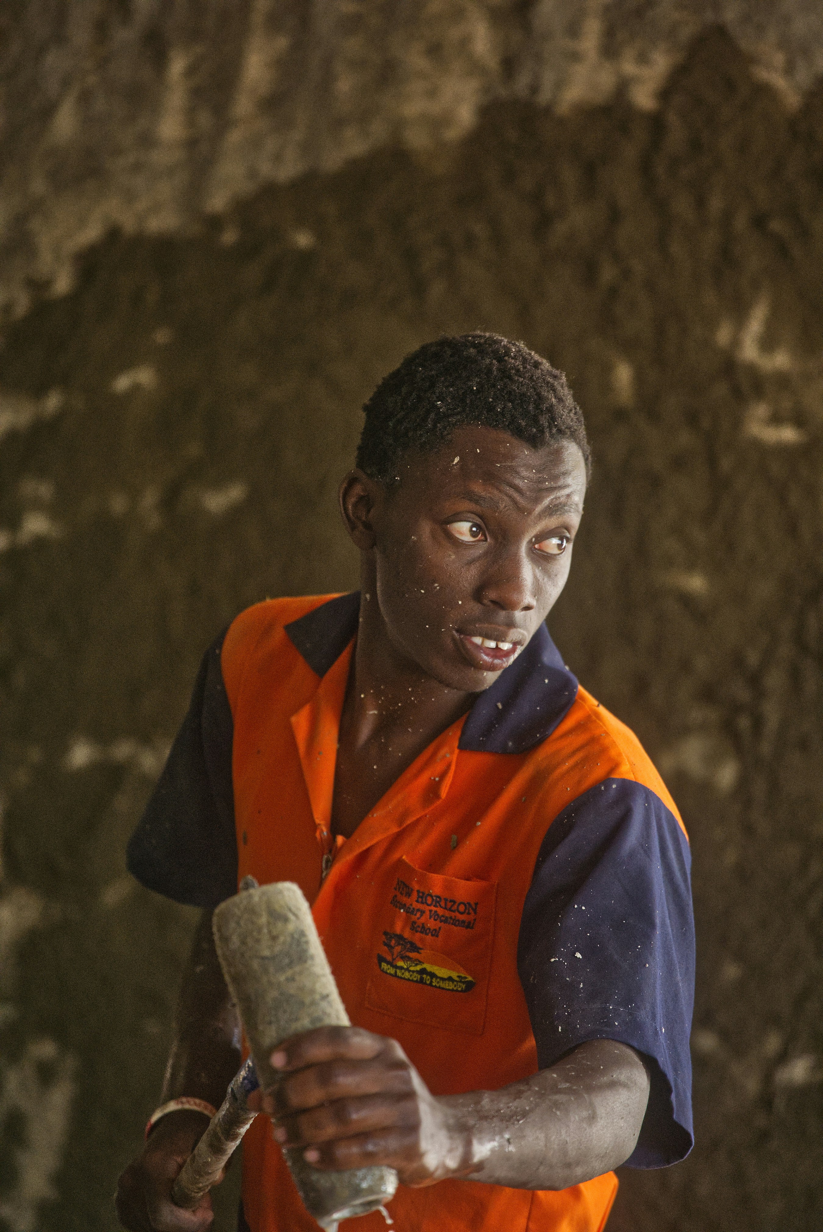 Worker in orange vest shifts gaze under a cave-like roof
