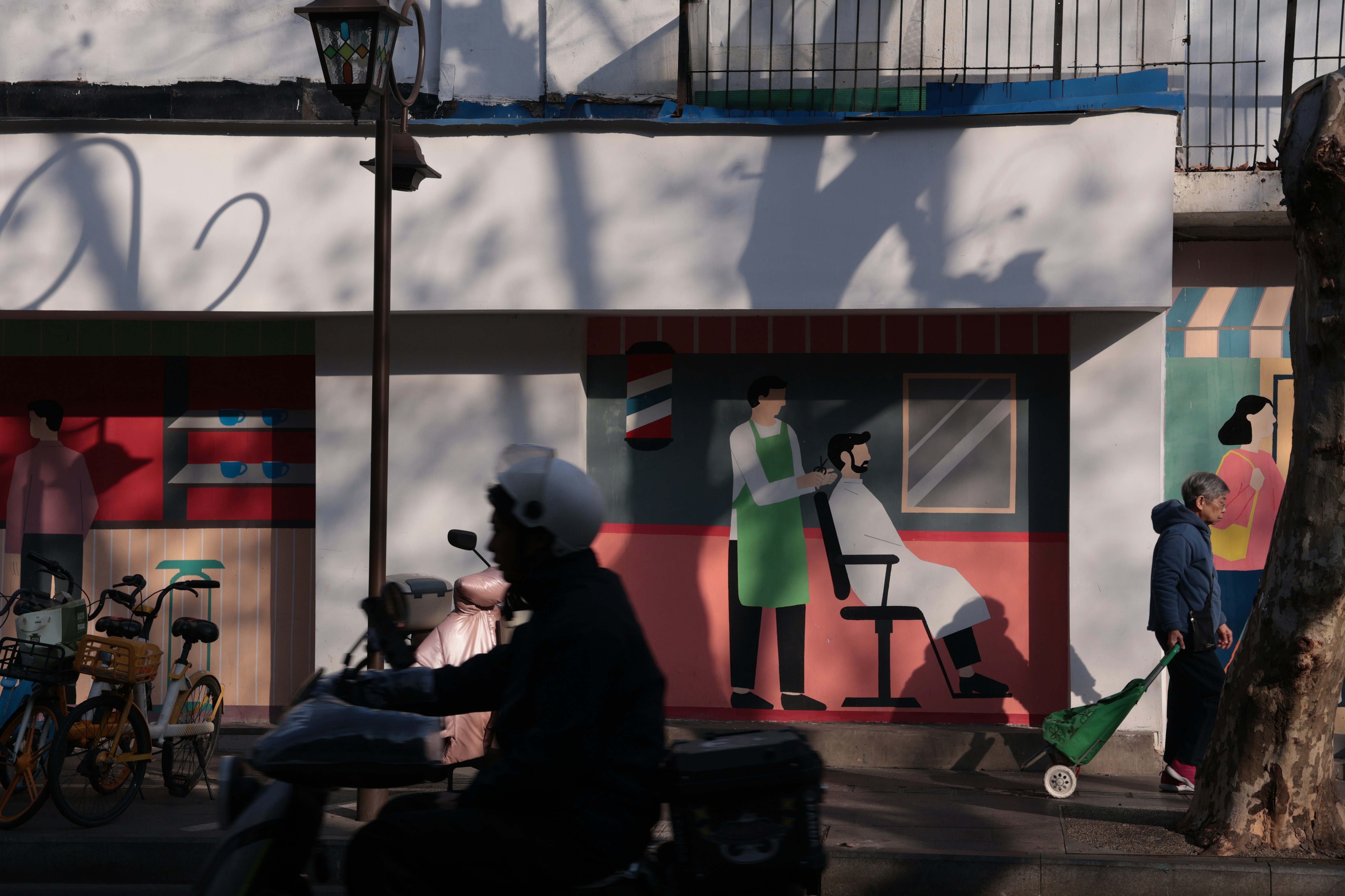 Street mural life: barber chair and passerby silhouette amid a bustling storefront