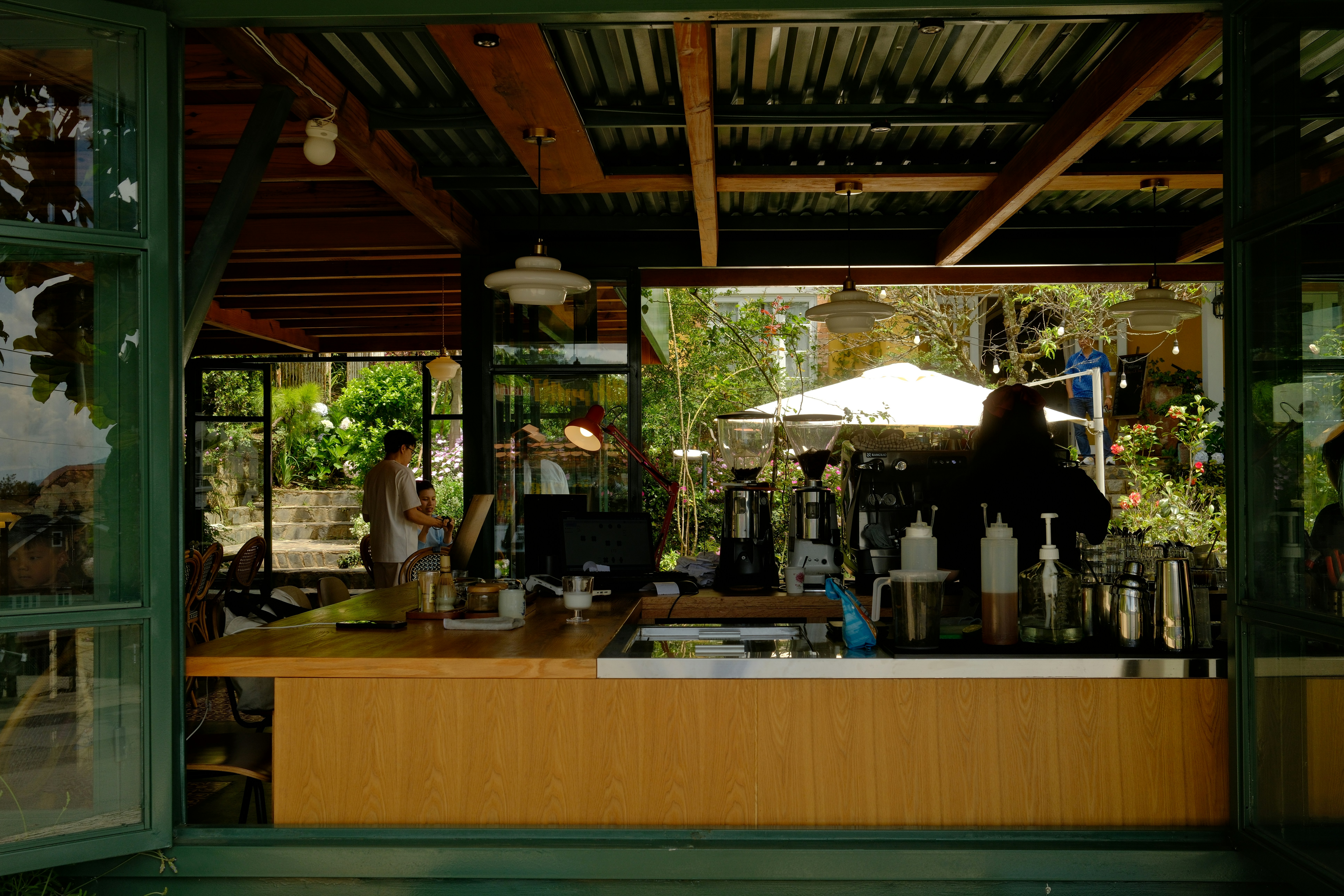 Open-air café bar through glass doors at golden hour