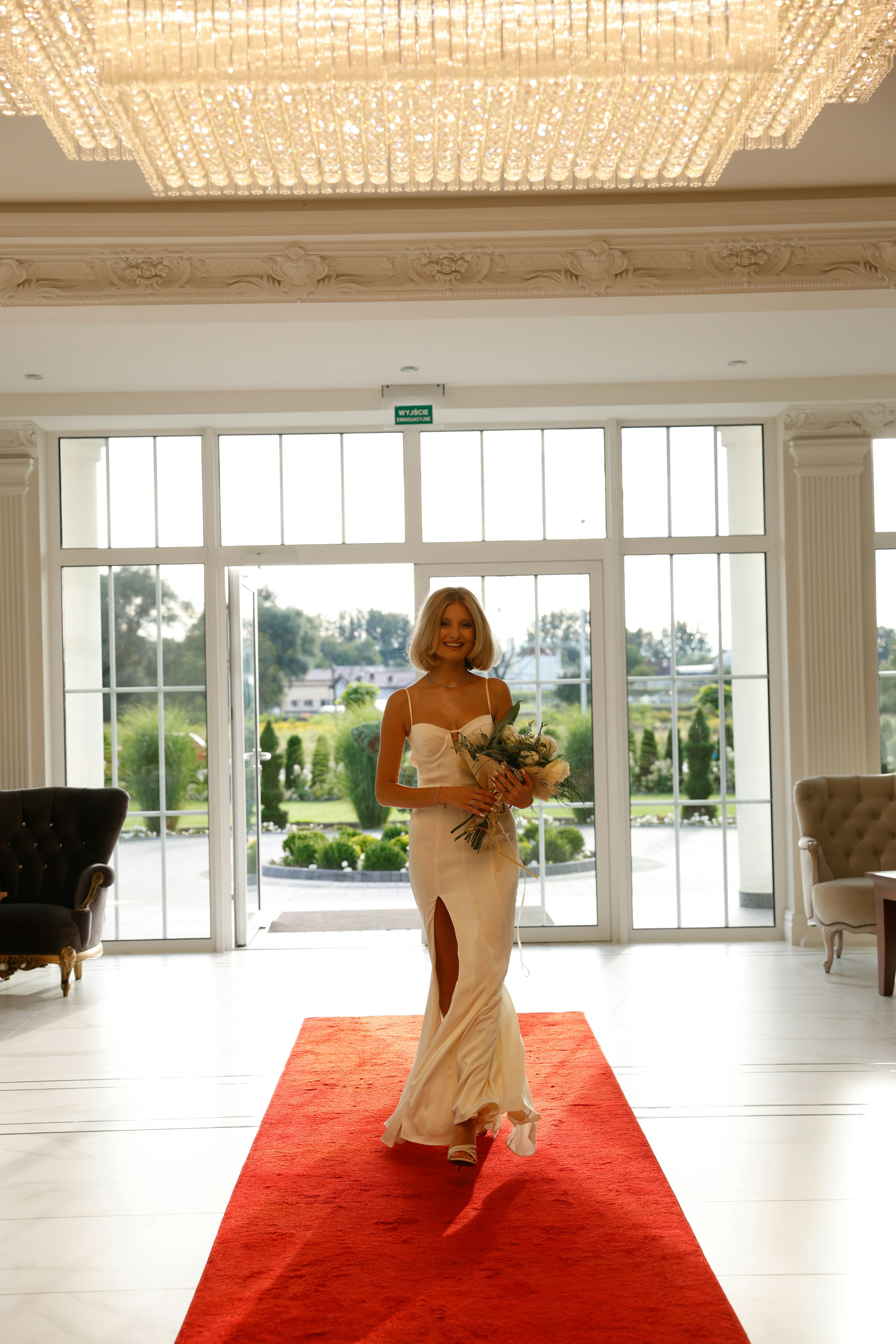 Bride Steps onto a Red Carpet: Elegant Moment in a Sunlit Salon