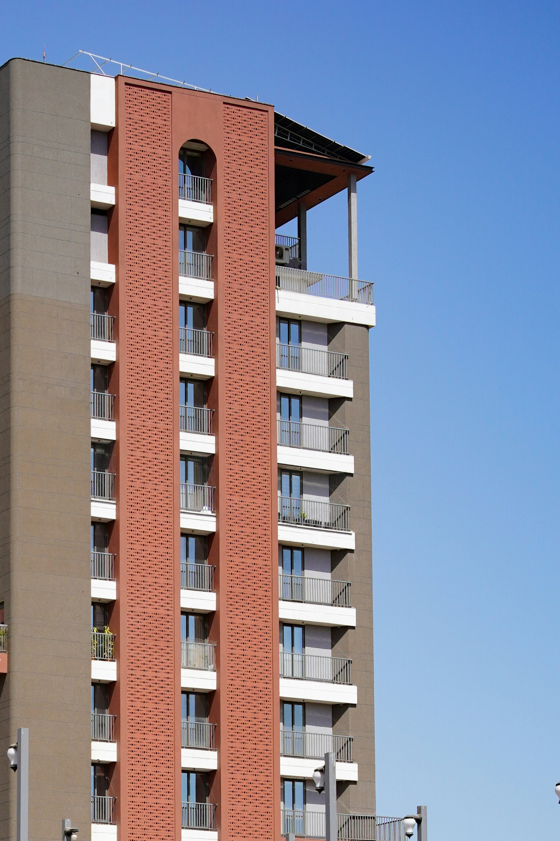 Vertical City: Red Brick Tower Stretching Toward a Clear Blue Sky