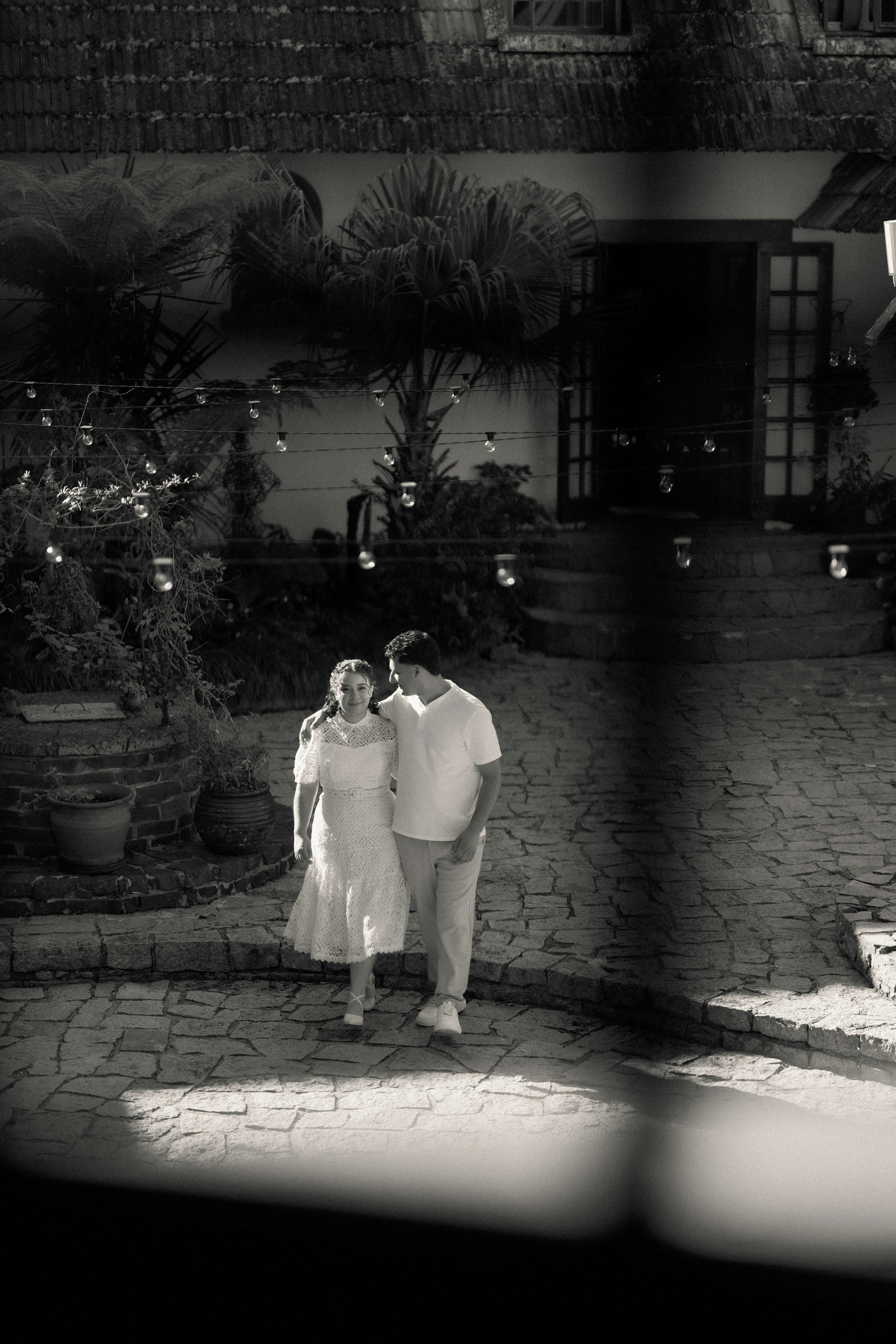 Lovers on a Stone Path Under String Lights