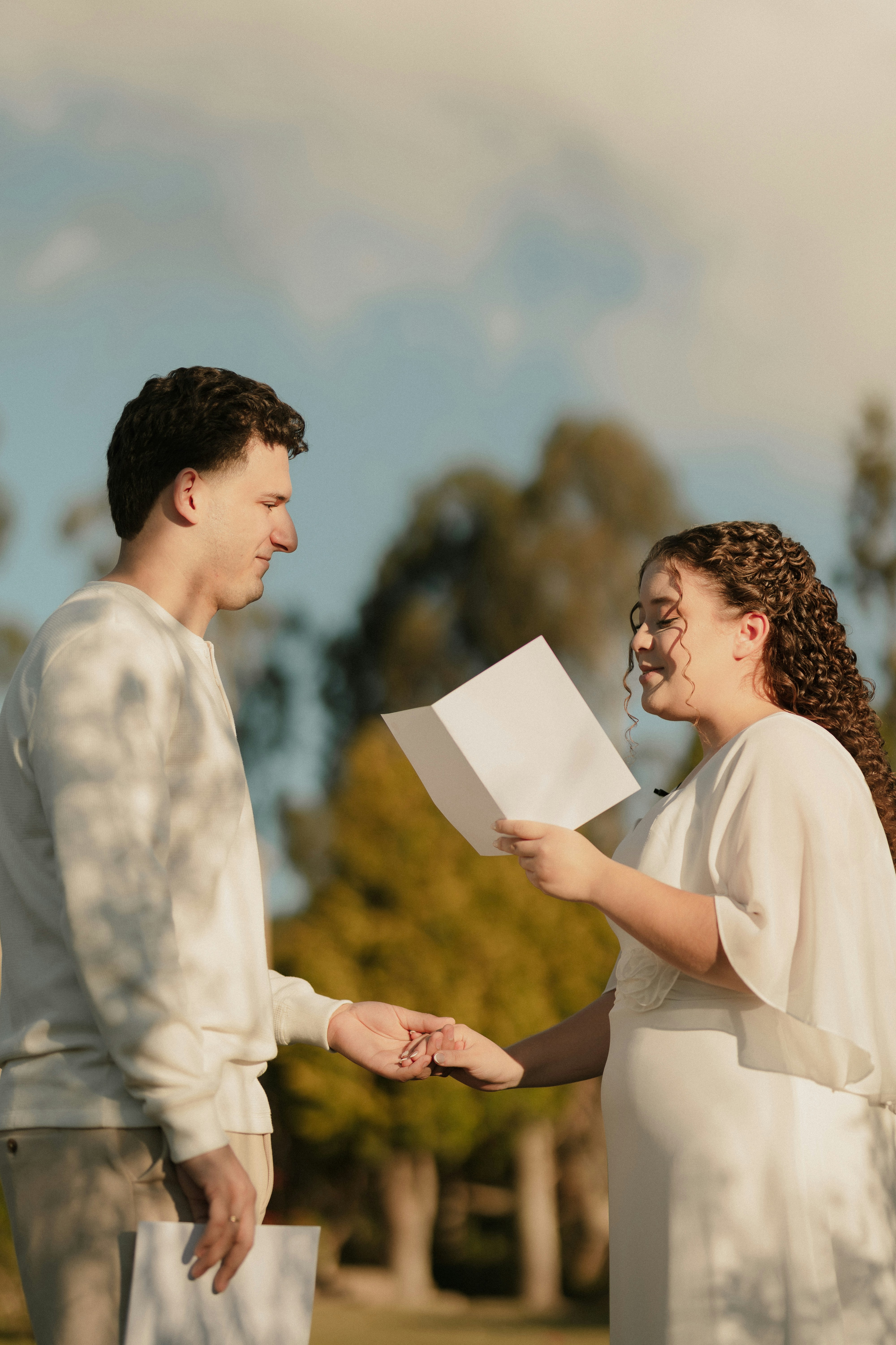 Vows Between Hands: A Moment of Ceremony in Soft Sunset Light