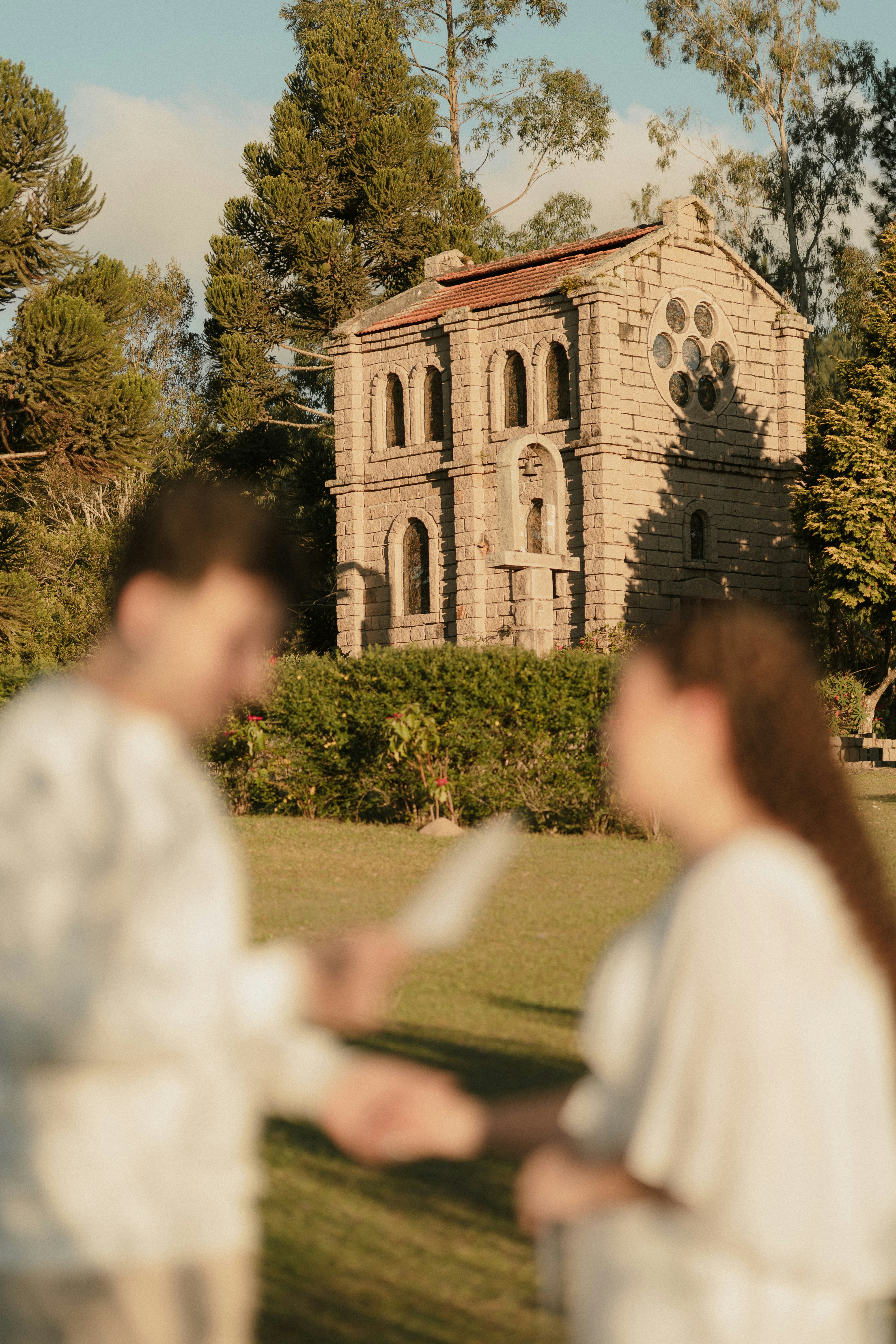 Stone Chapel Backdrop: a Quiet Moment Between Two Figures