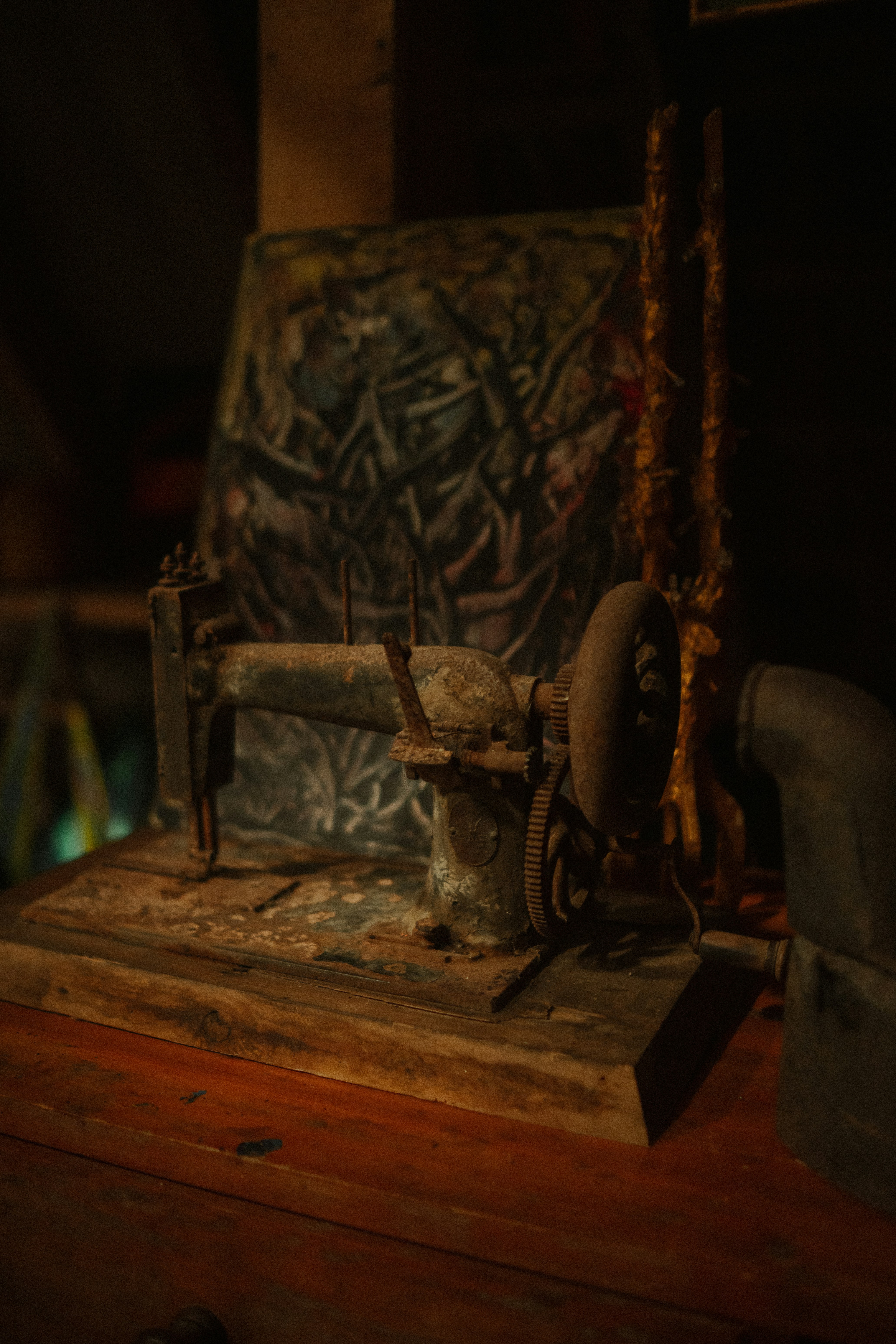 Dust-Caked Stitcher: An Antique Sewing Machine in a Shadowed Workshop