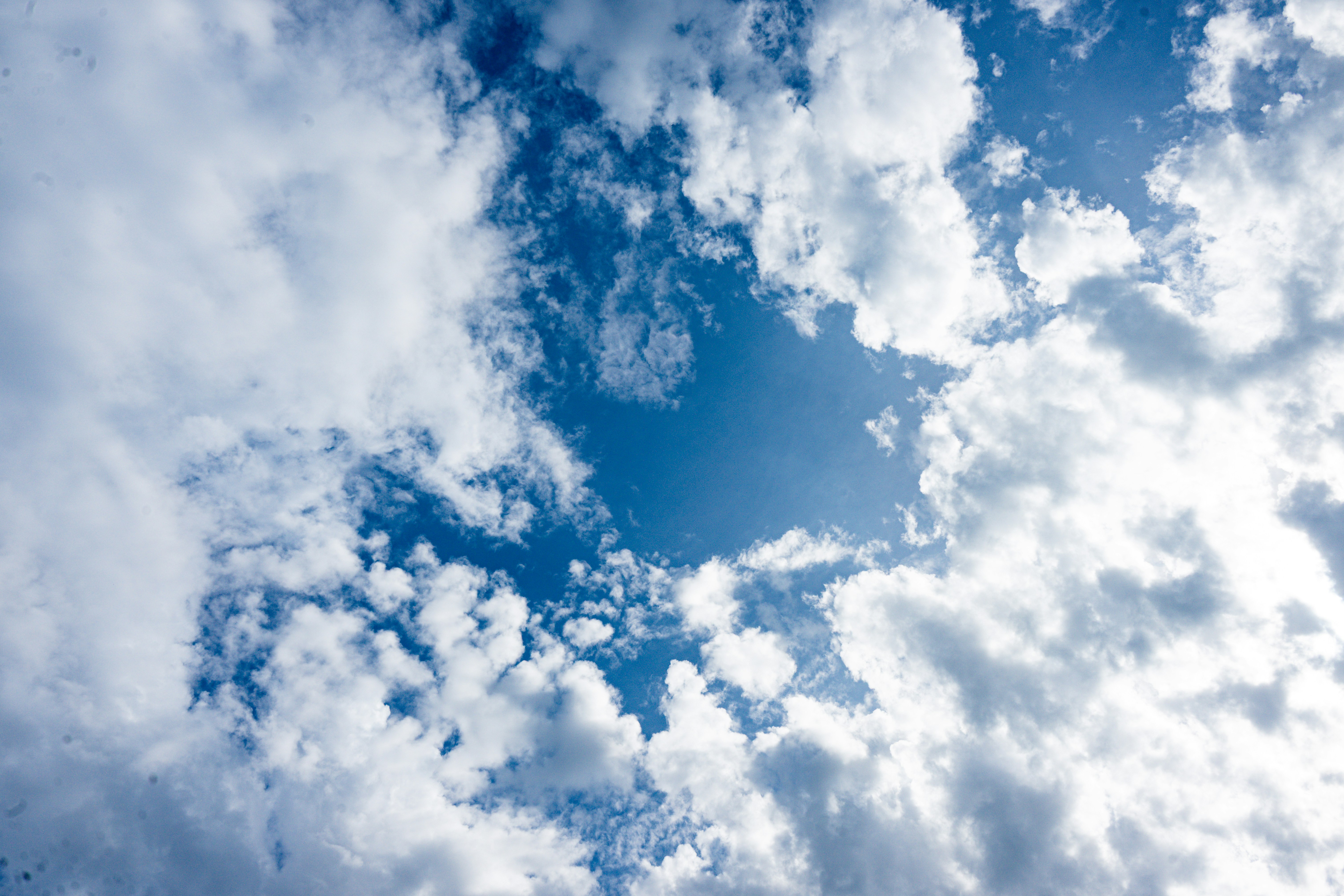Open Skybreak: Clouds Torn Across a Clear Blue Void