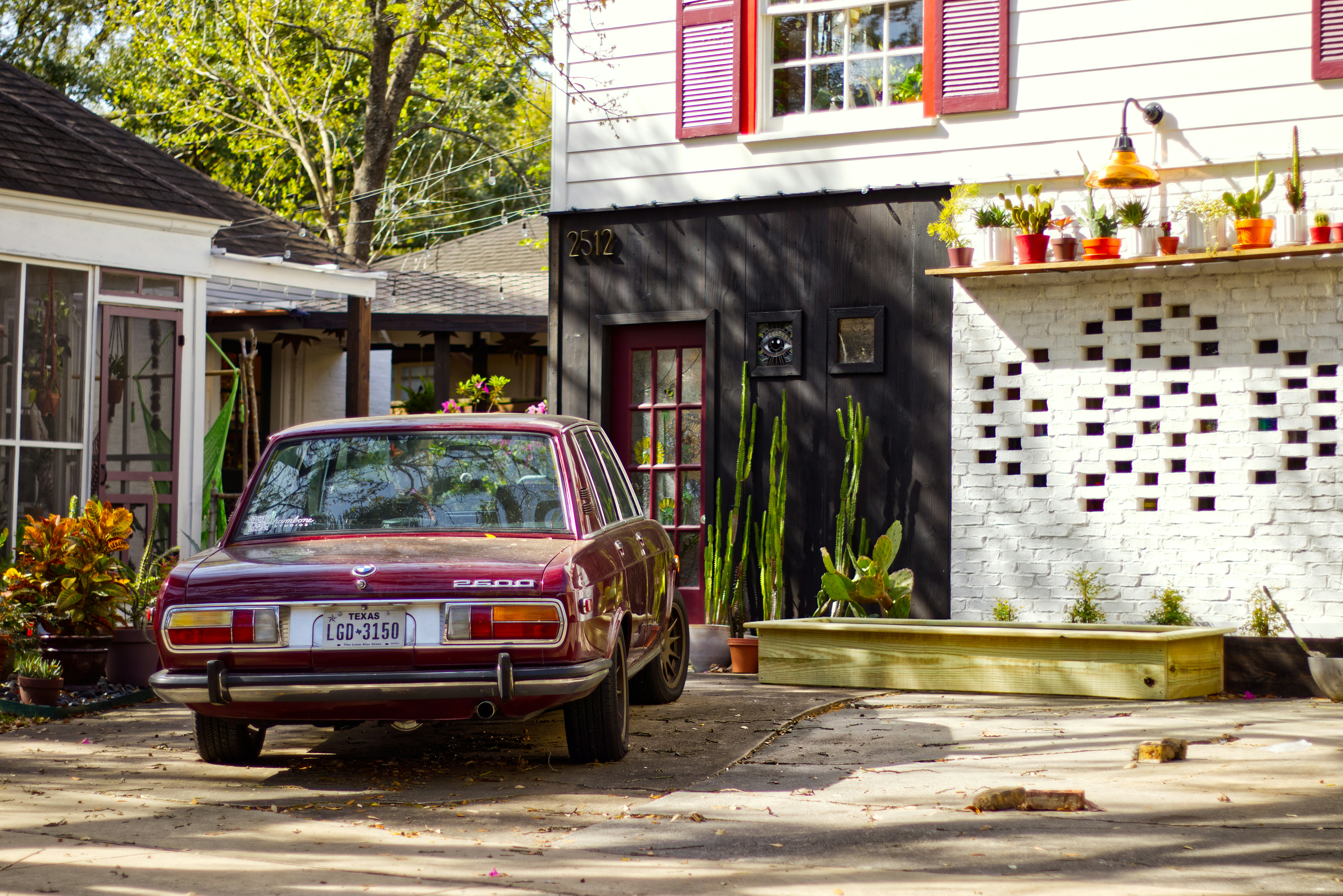 Sunlit Street Scene with a Classic Car in Front of a Quaint House