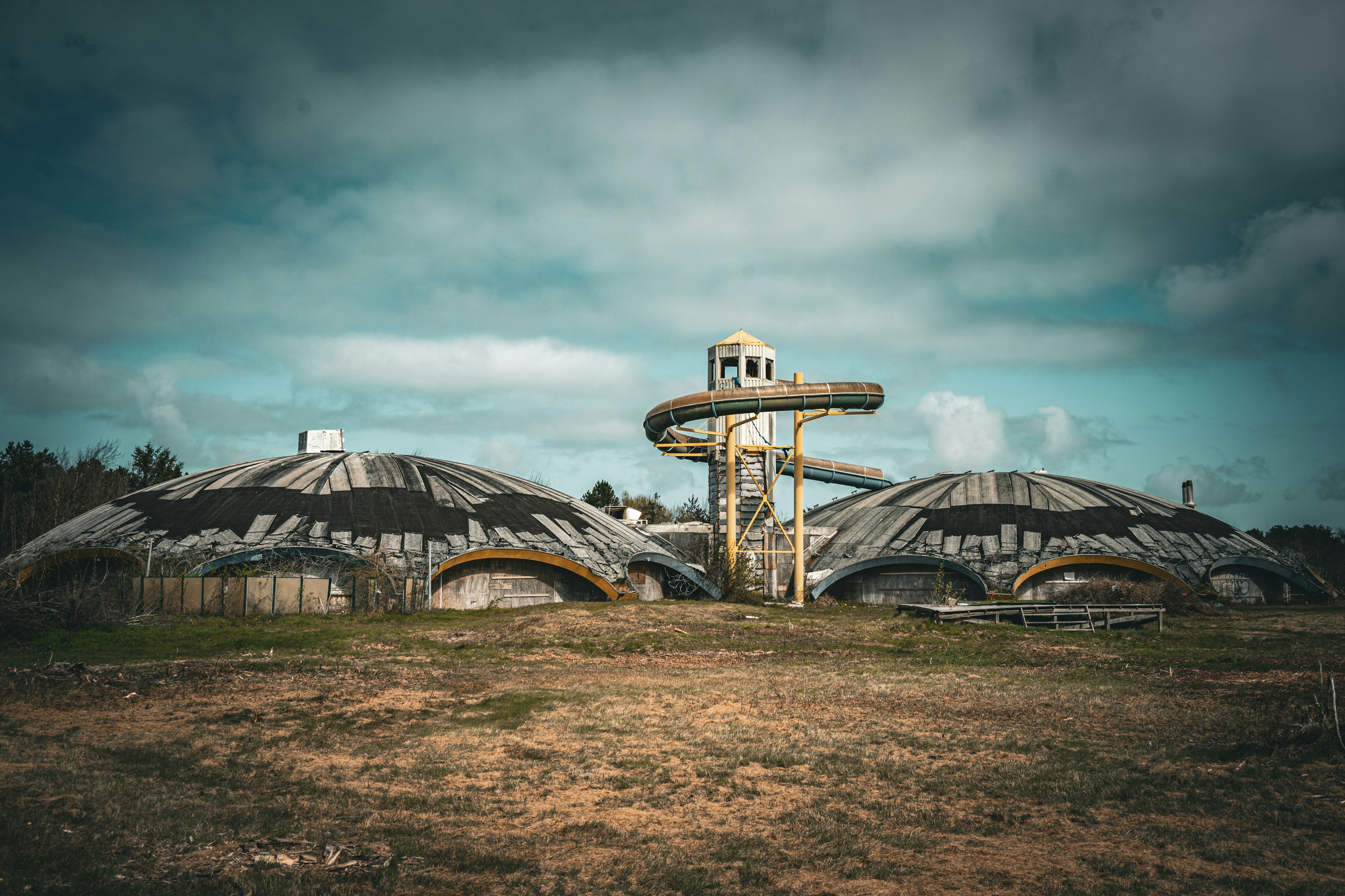 Concrete domes and a central tower: a solar-arc playground of weathered structures