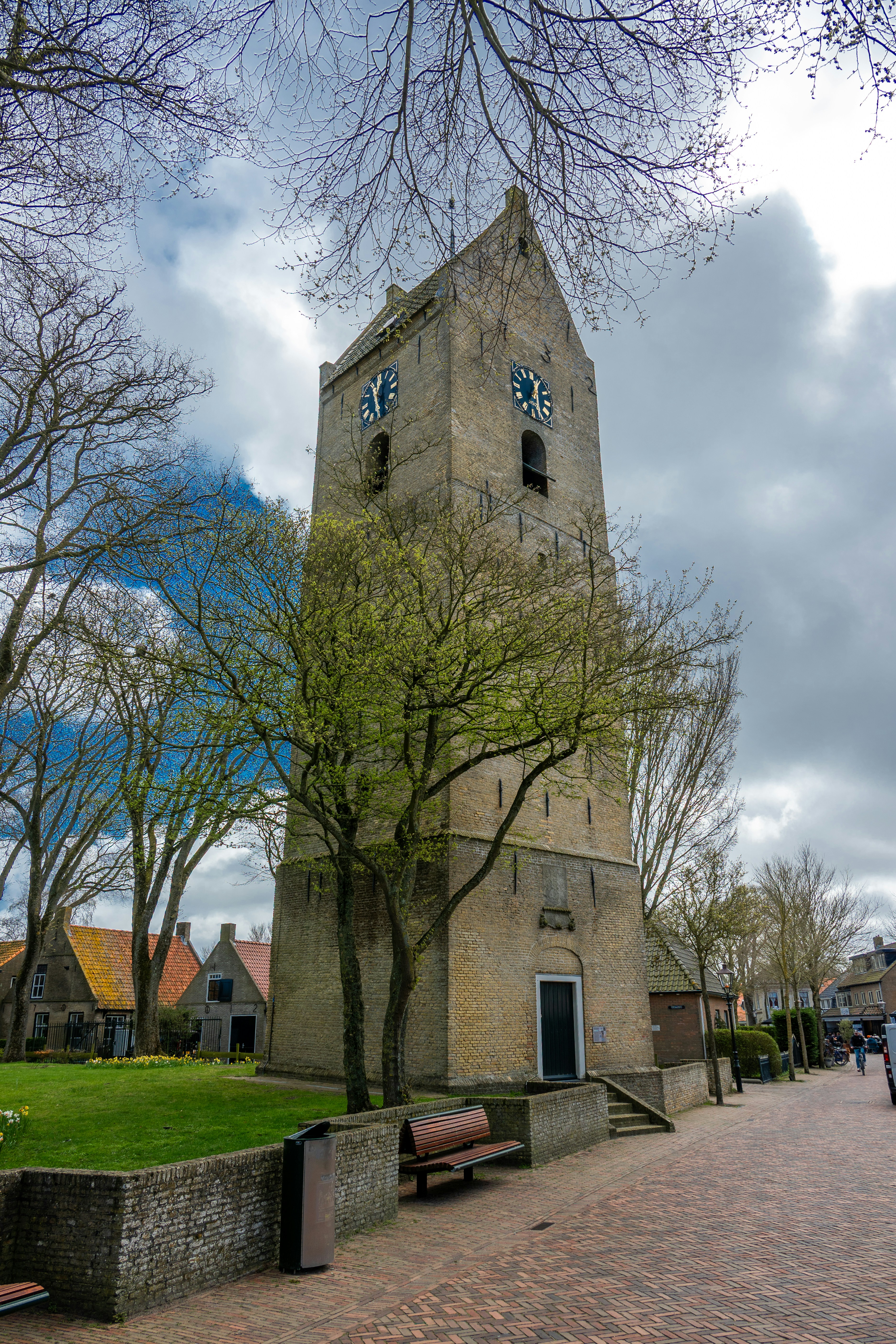 Towering Timekeeper: A Village Clock Tower Amid Spring Canopies