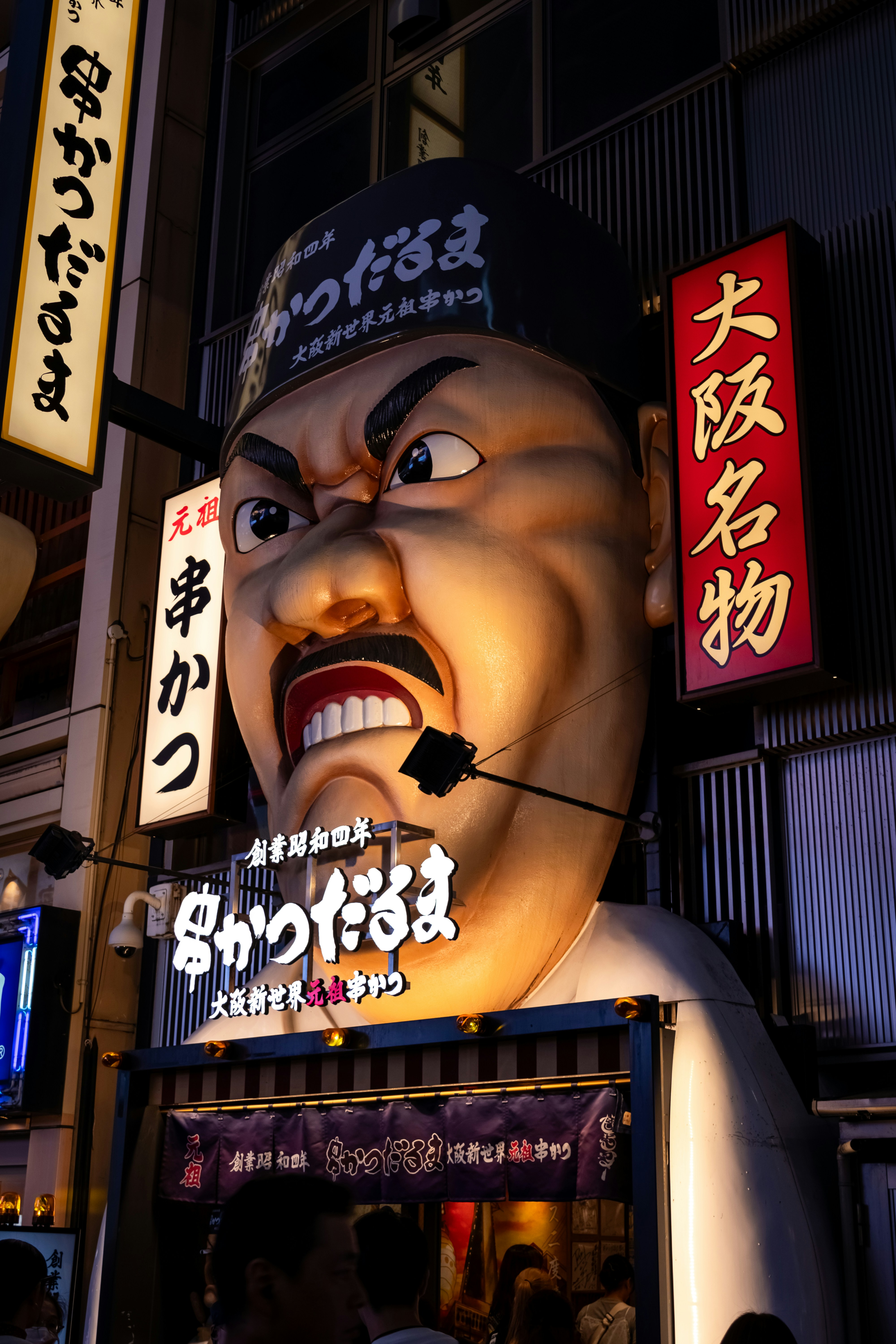 Giant Osaka Staple: A Fiery Mascot Guards Neon Night