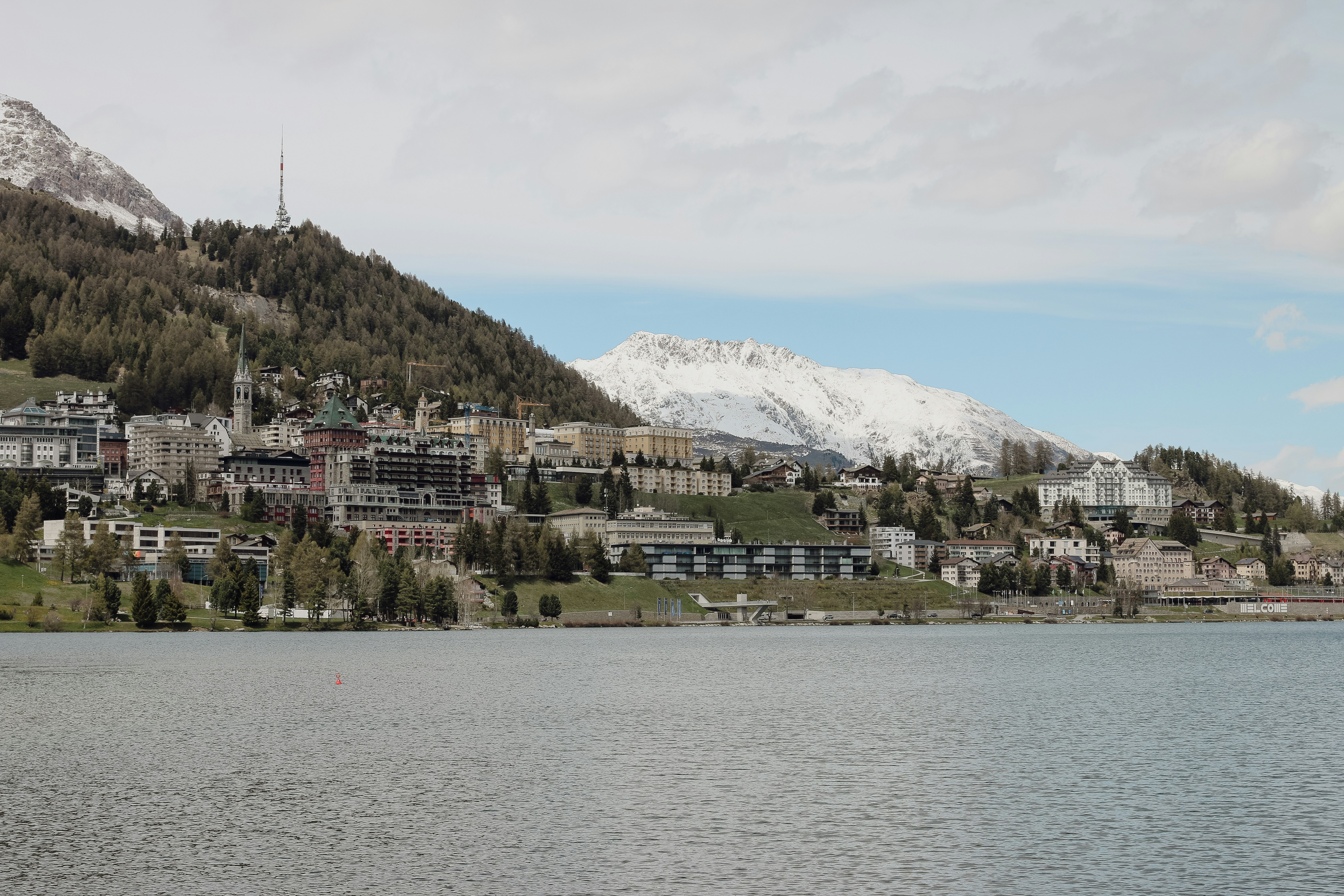 Lakeside Town Under Snow-Capped Peaks
