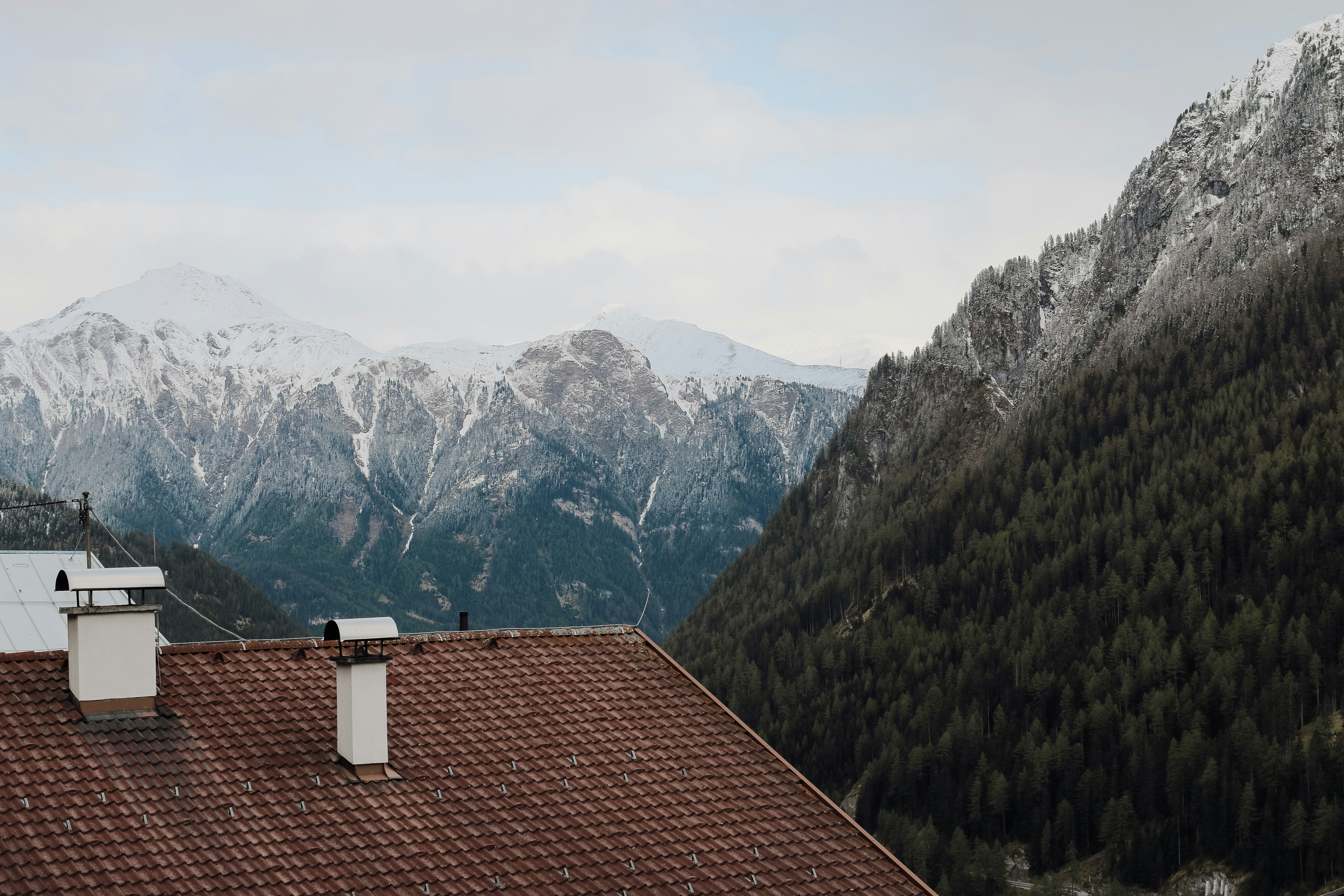 Rooflines Meet Alpine Giants: A Quiet Corner Beneath Snowbound Peaks