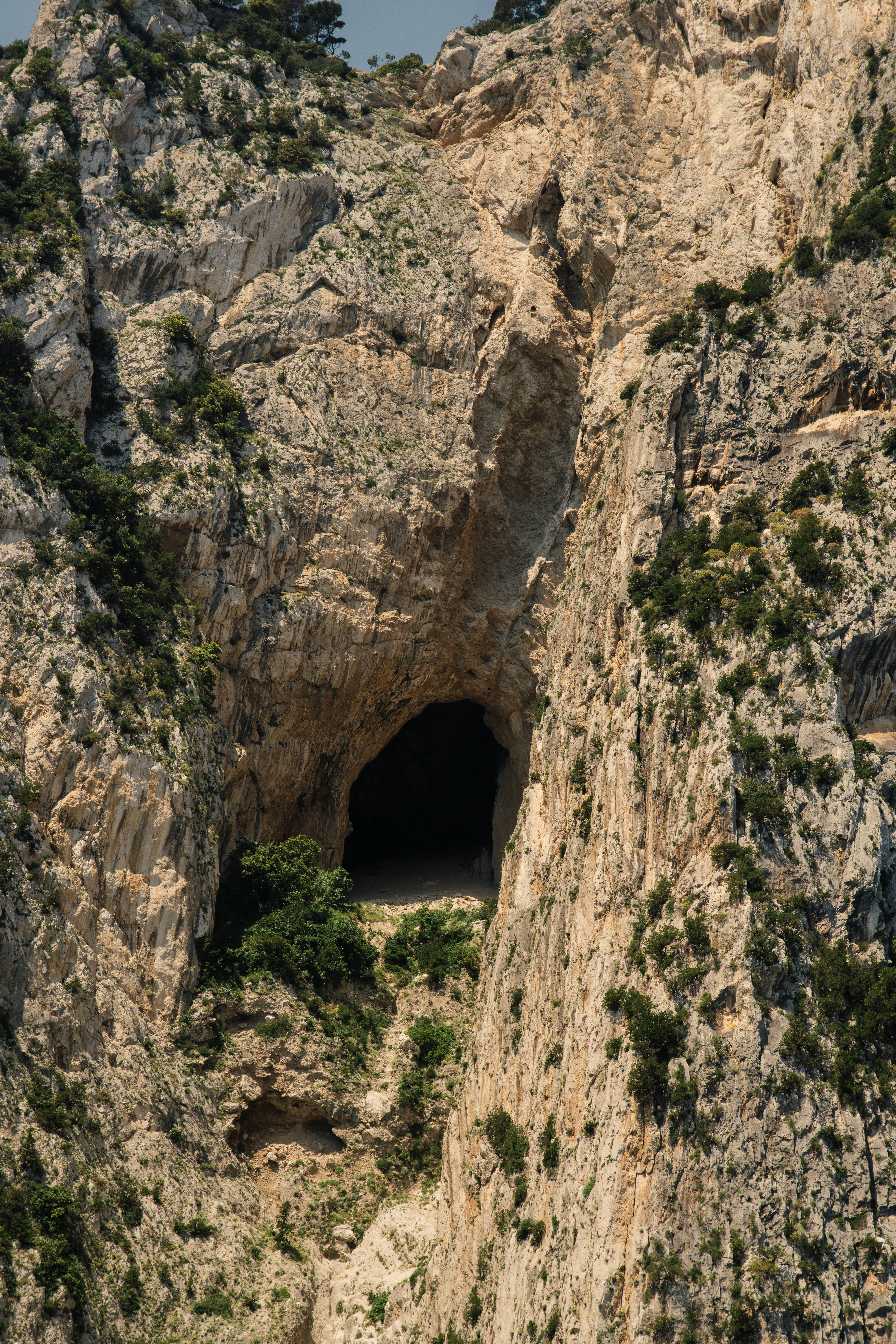 A large cave entrance in a rugged rocky cliff. photo – Free Texture ...