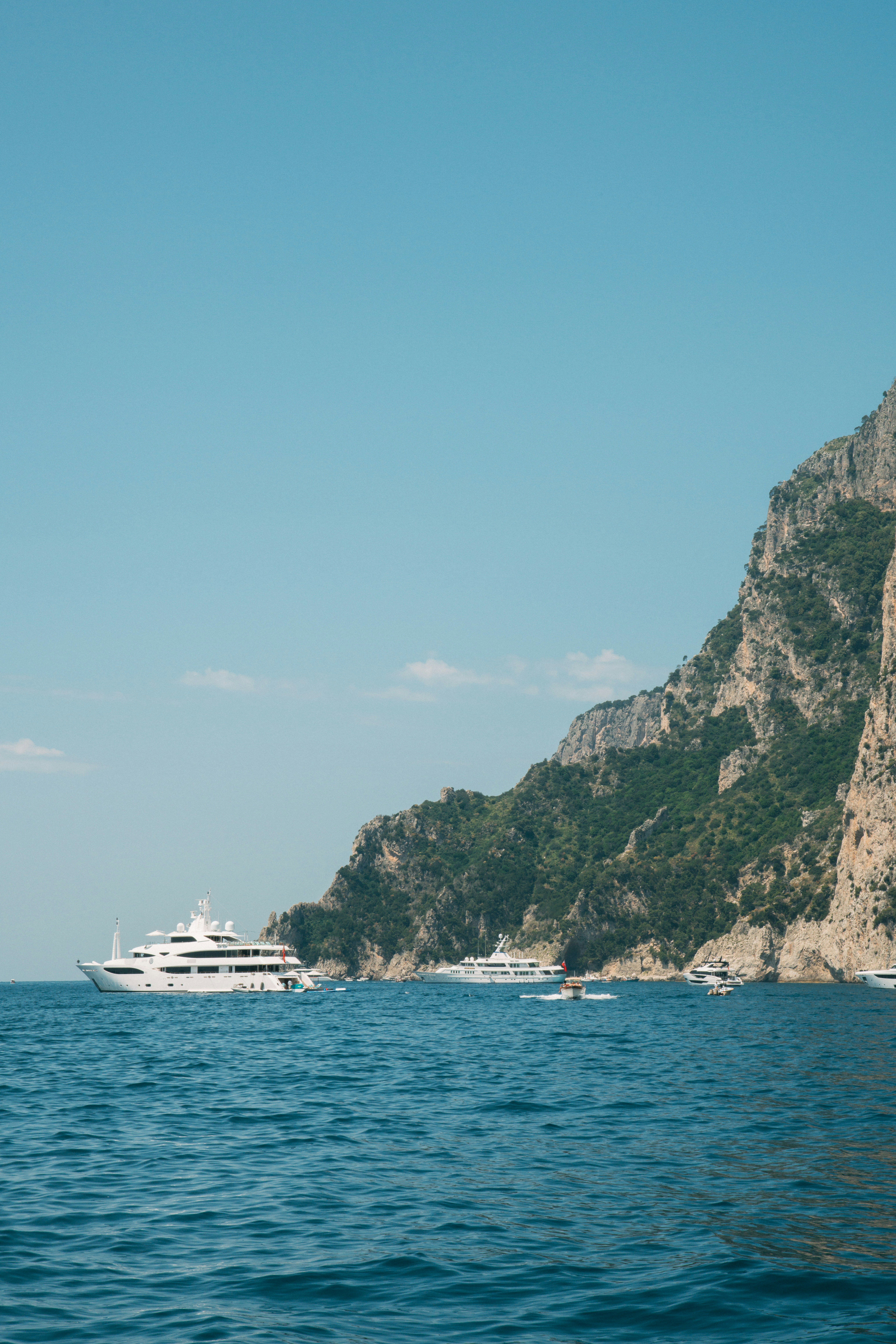  yachts Anchored at the Blue Gap Between Sea and Cliff