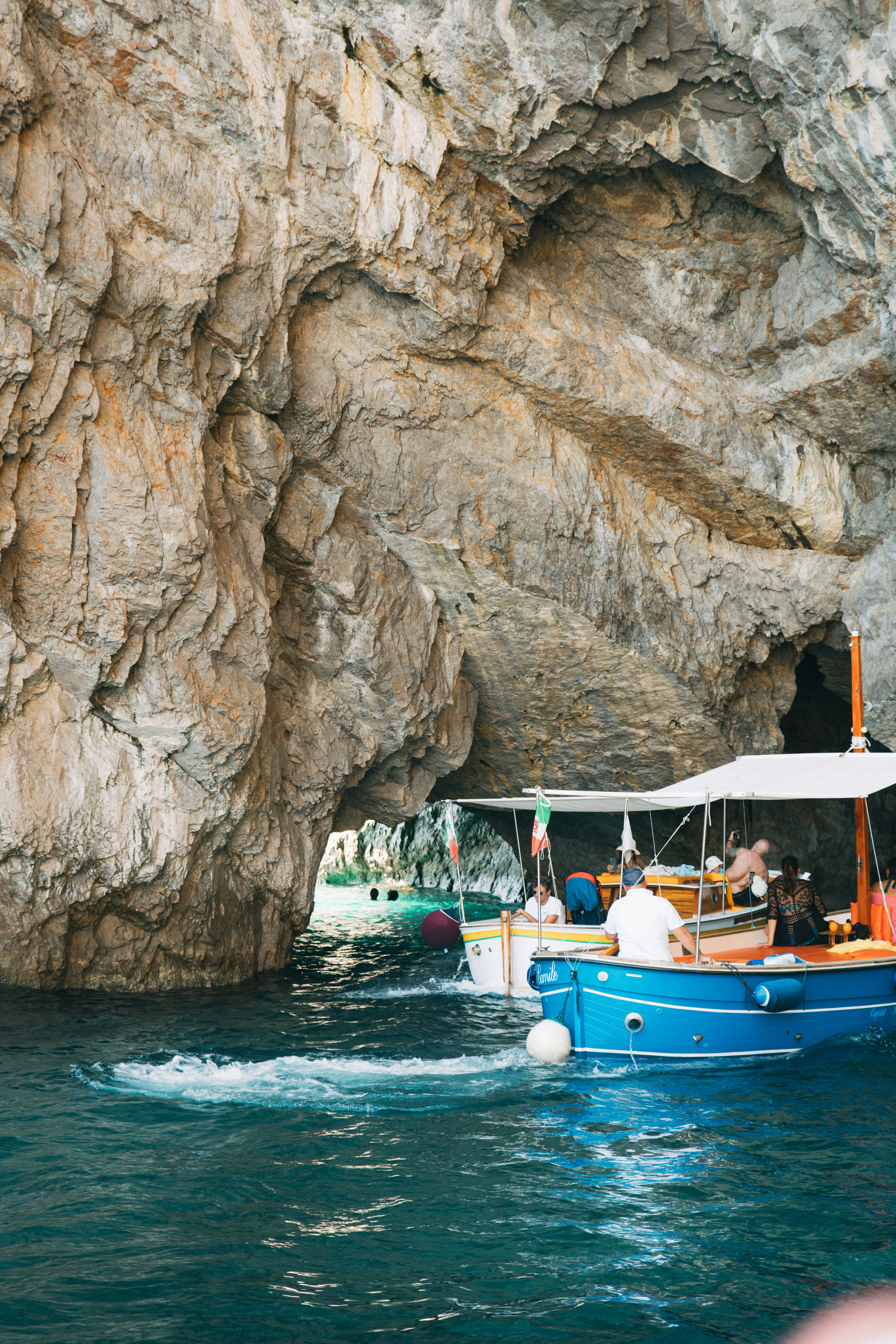 Emerald Passage: Boat Lodged Beneath a Coastal Cliff