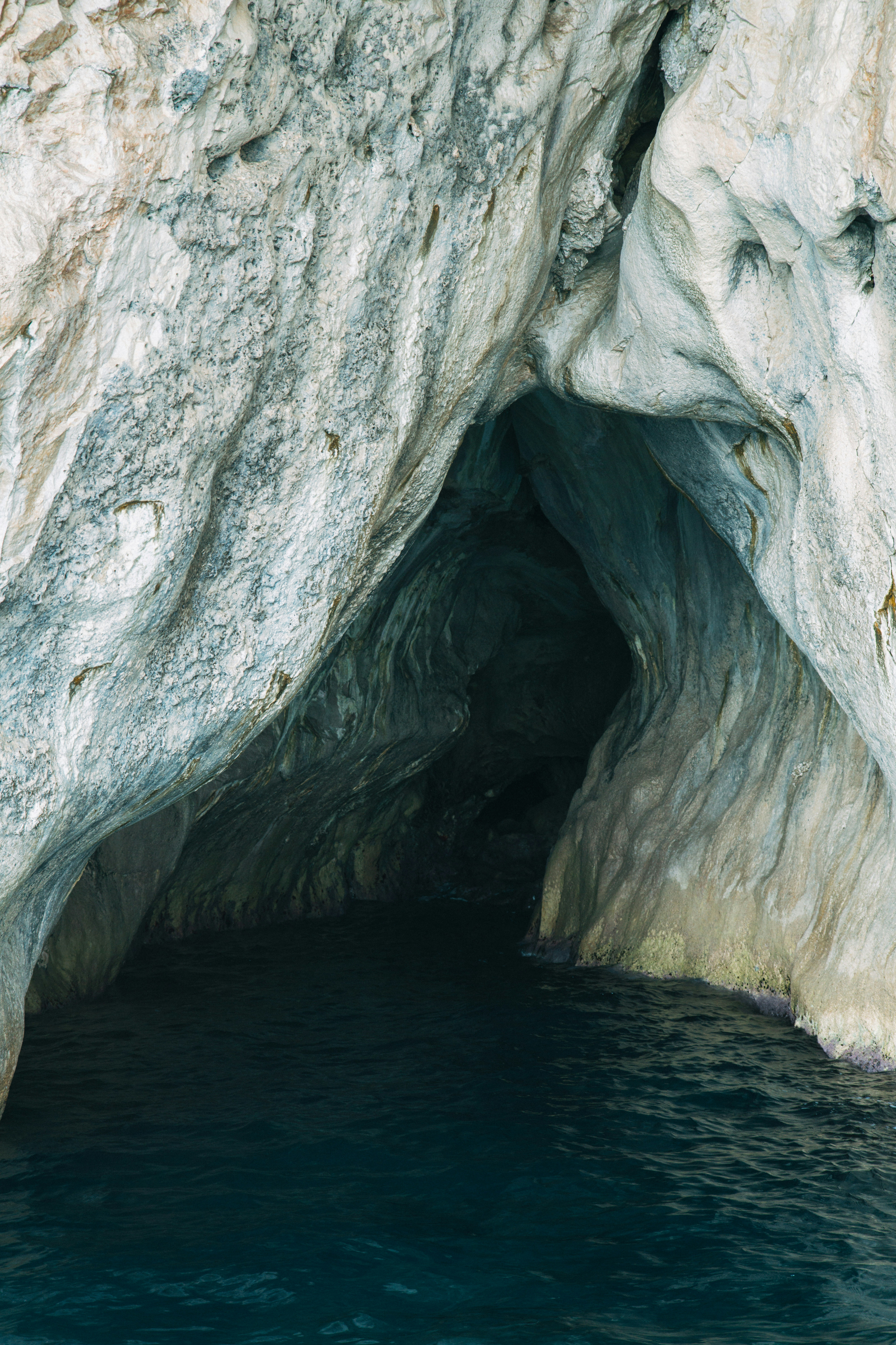 Sea cave silhouette: water at the mouth of a rocky arch
