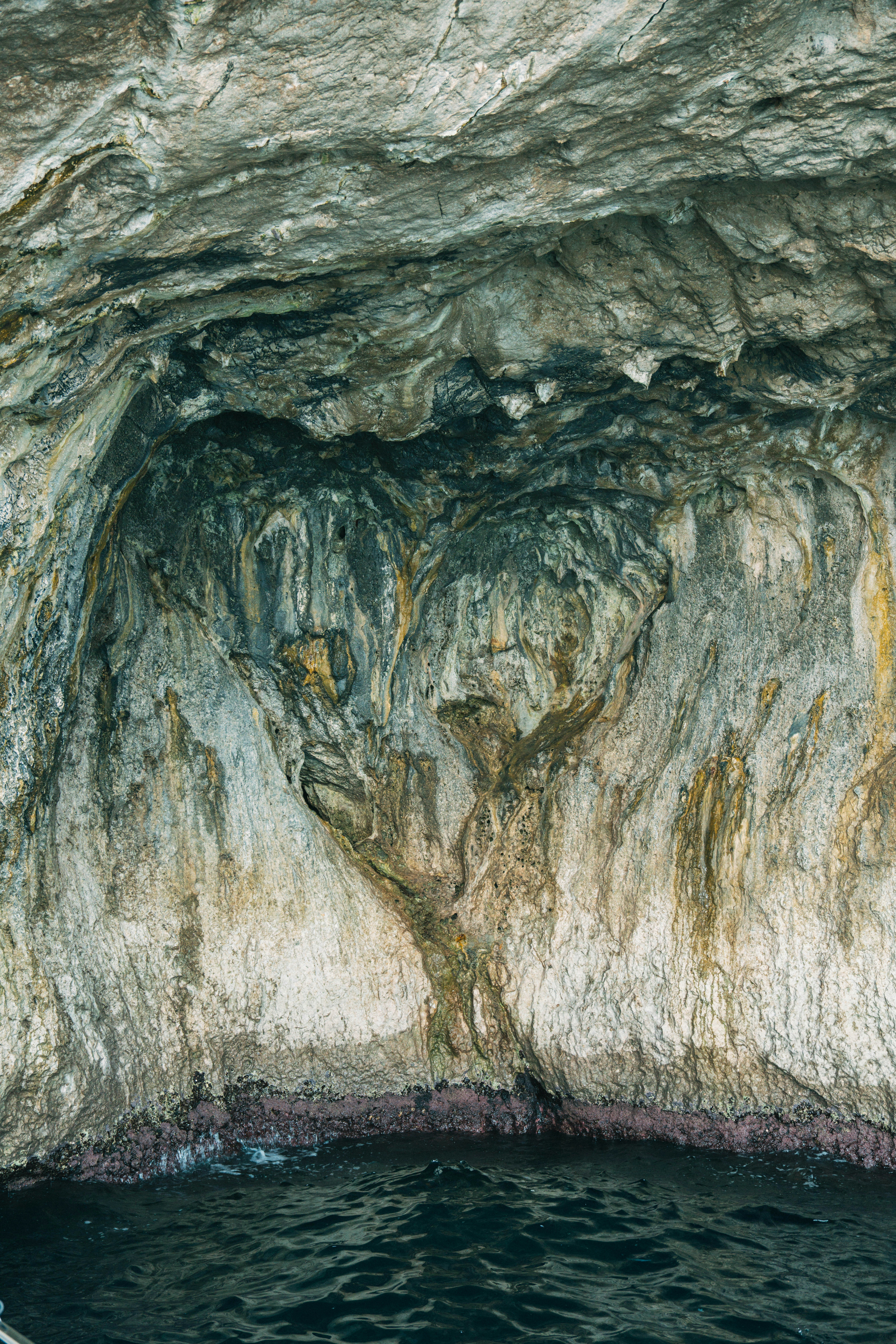 Cavern Echoes: Vertical Cliff Face Meeting a Dark Sea