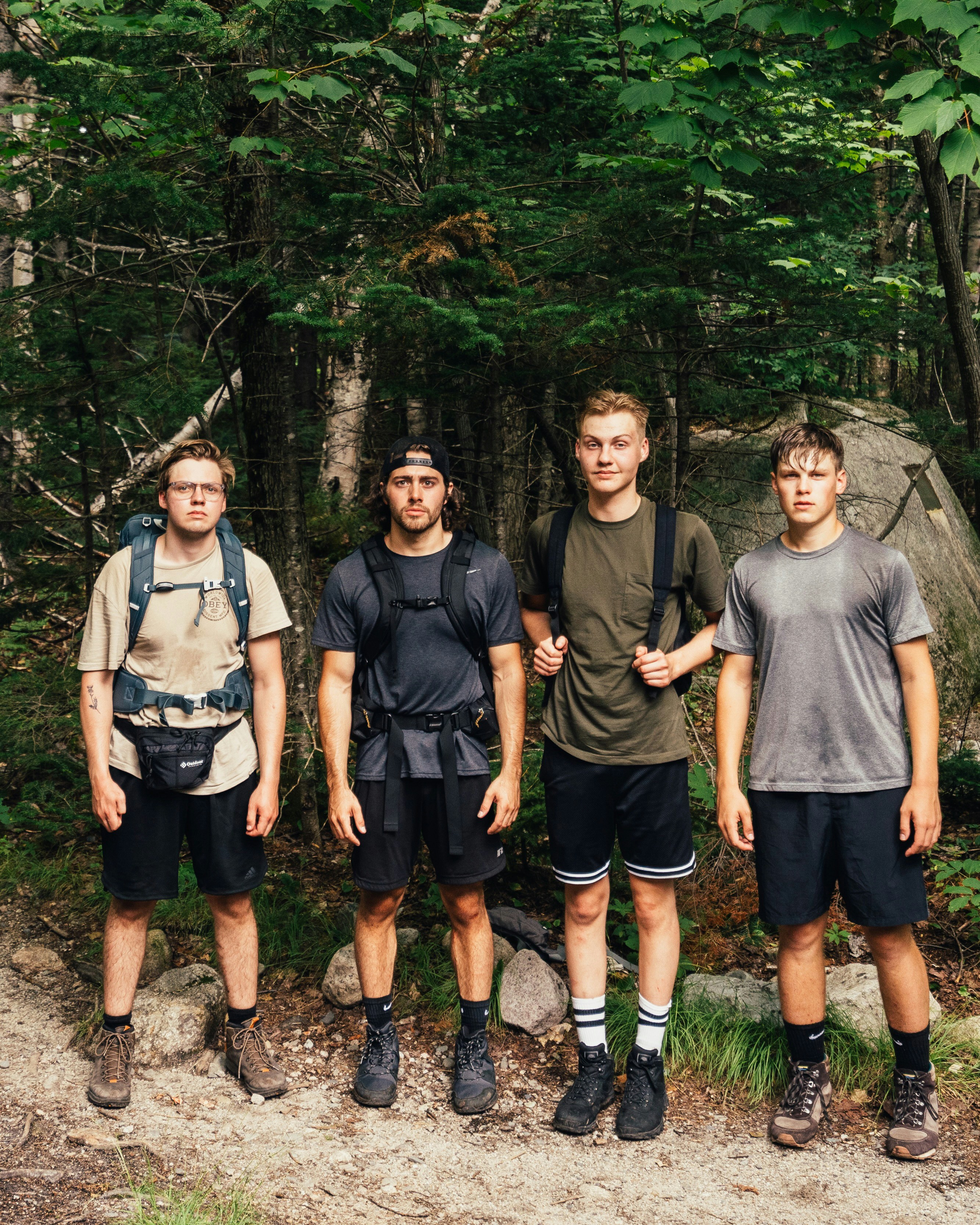 Quadruple Trail Crew: A Shot of Four Hikers Reclining into the Forest Edge