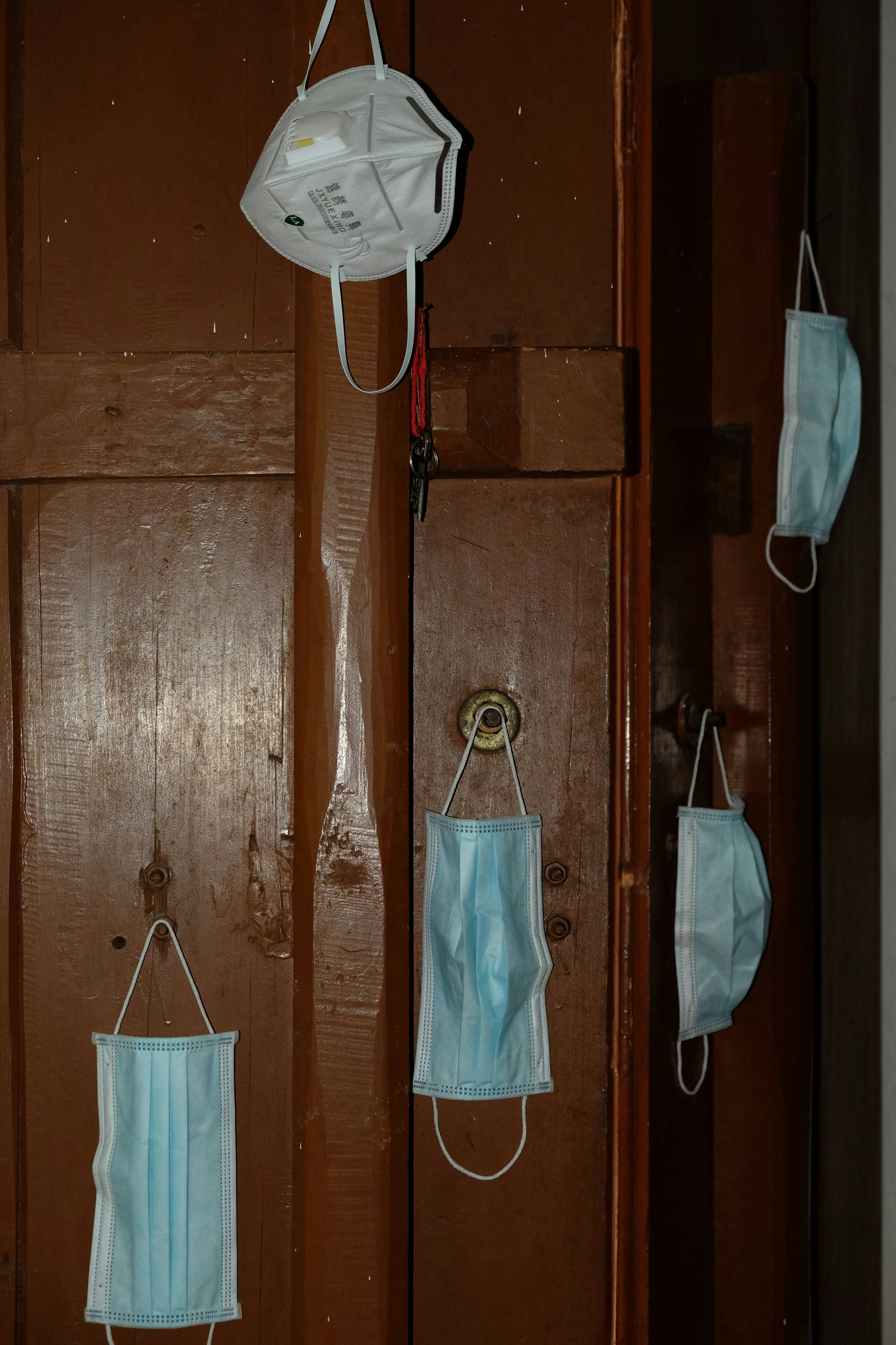 Masked quiet in the wardrobe: faces hidden among hanging masks