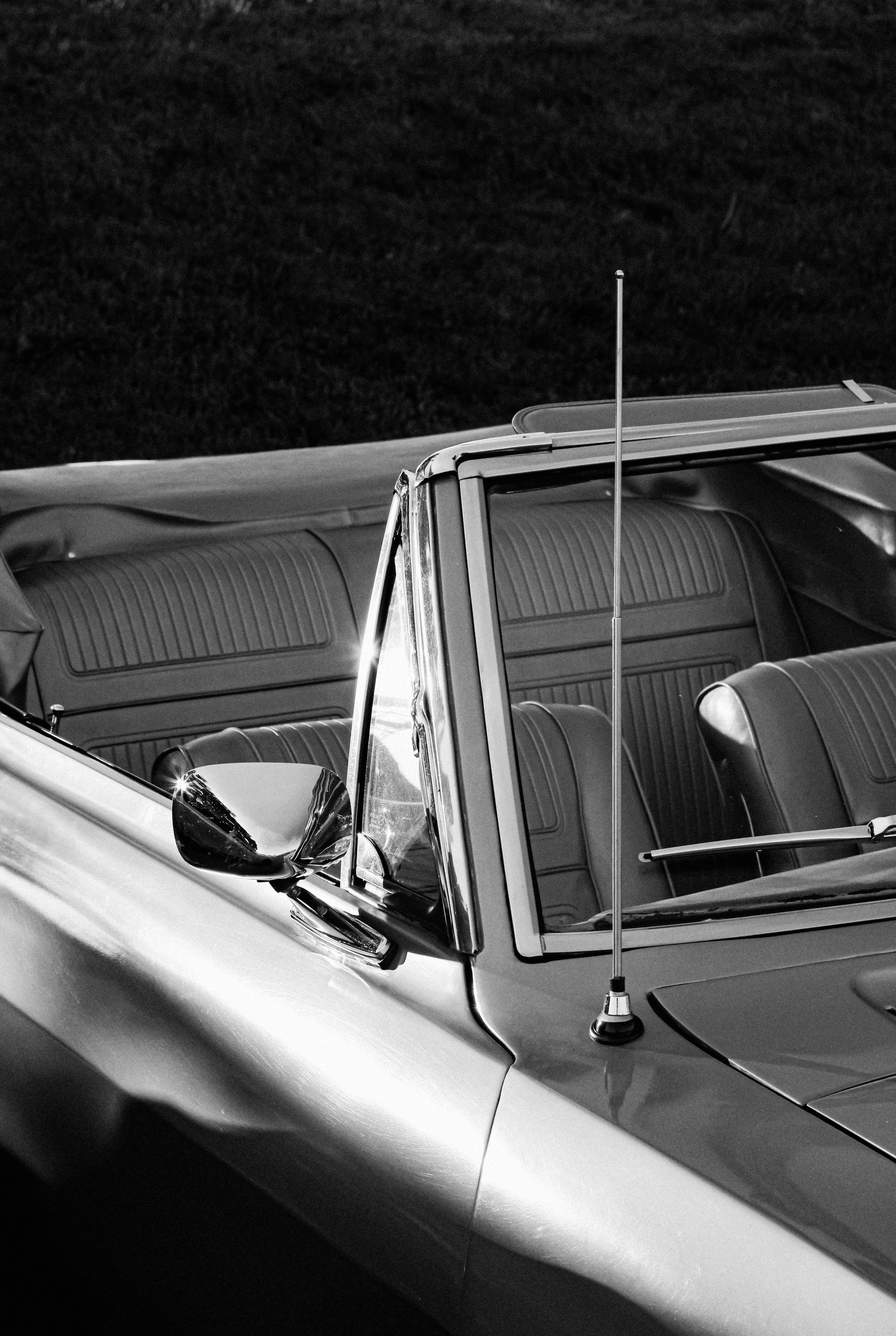 Chrome Reflections on a Classic Convertible: Close-Up of the Windshield and Antenna
