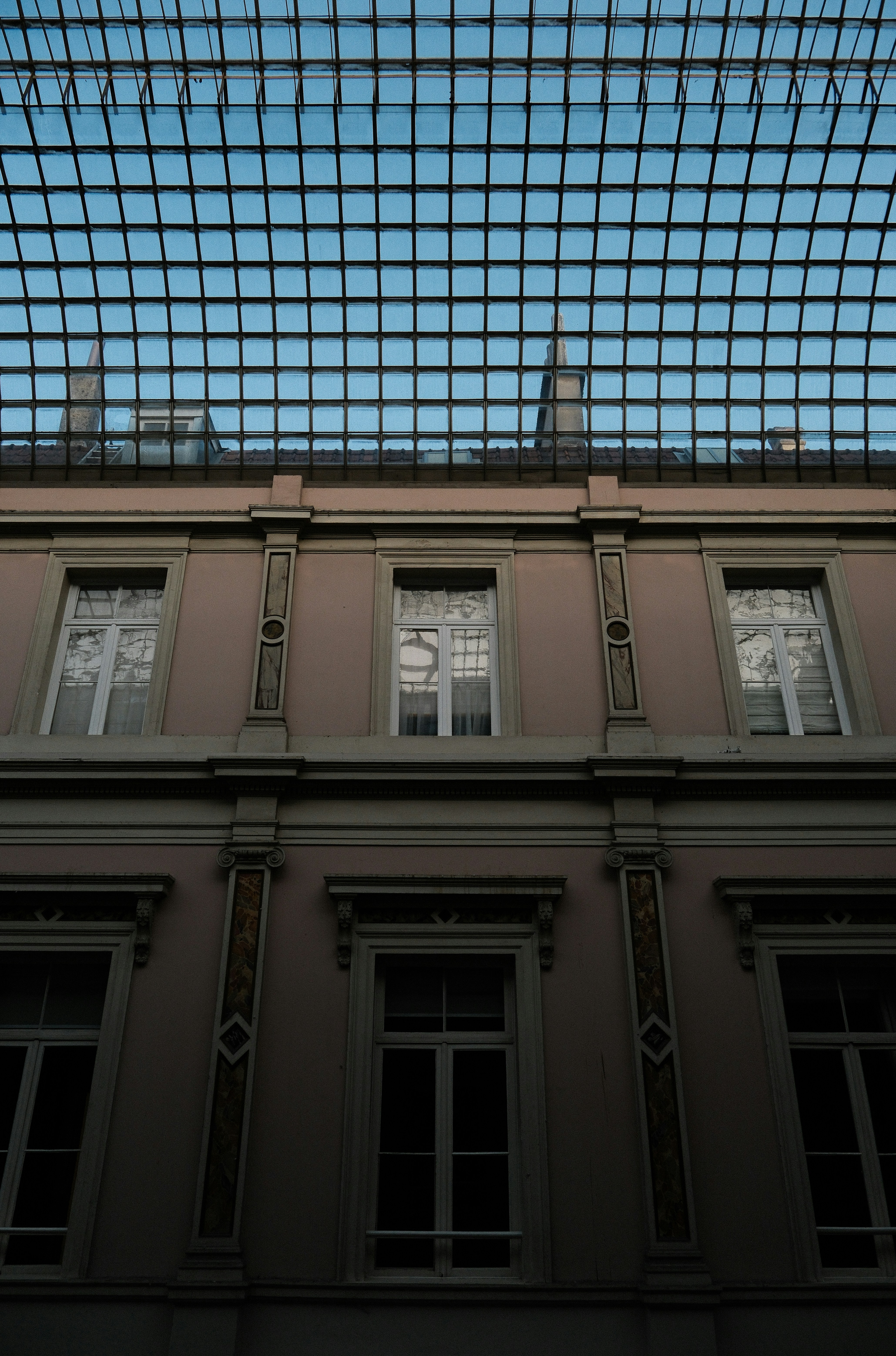 Grid of Glass and Stone: Facade Framed by a Skyward Mesh