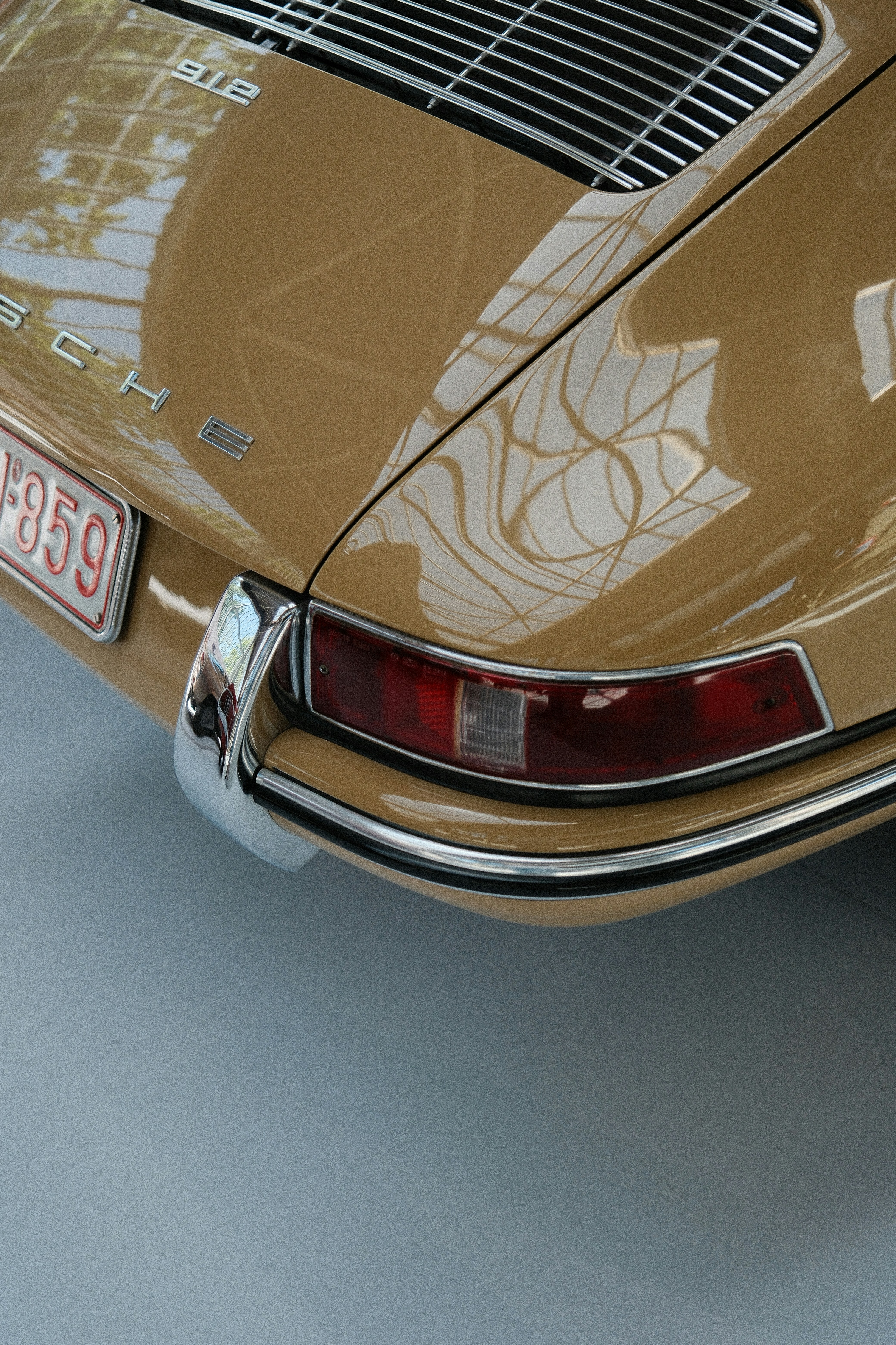Golden Classic: The Curved Silhouette and Taillight of a Vintage Porsche