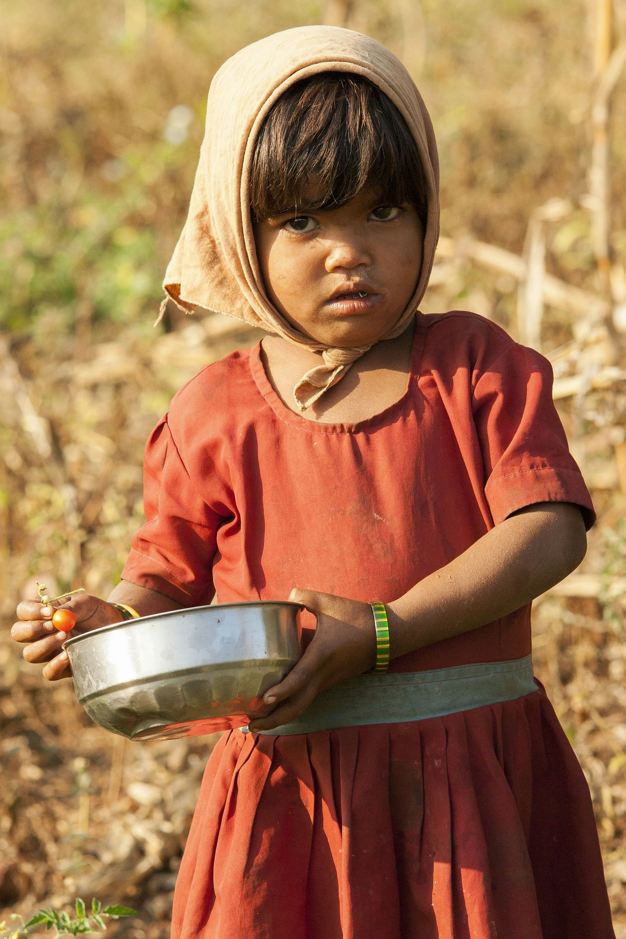 Child with Bowl: Warm Indian Sunlit Portrait