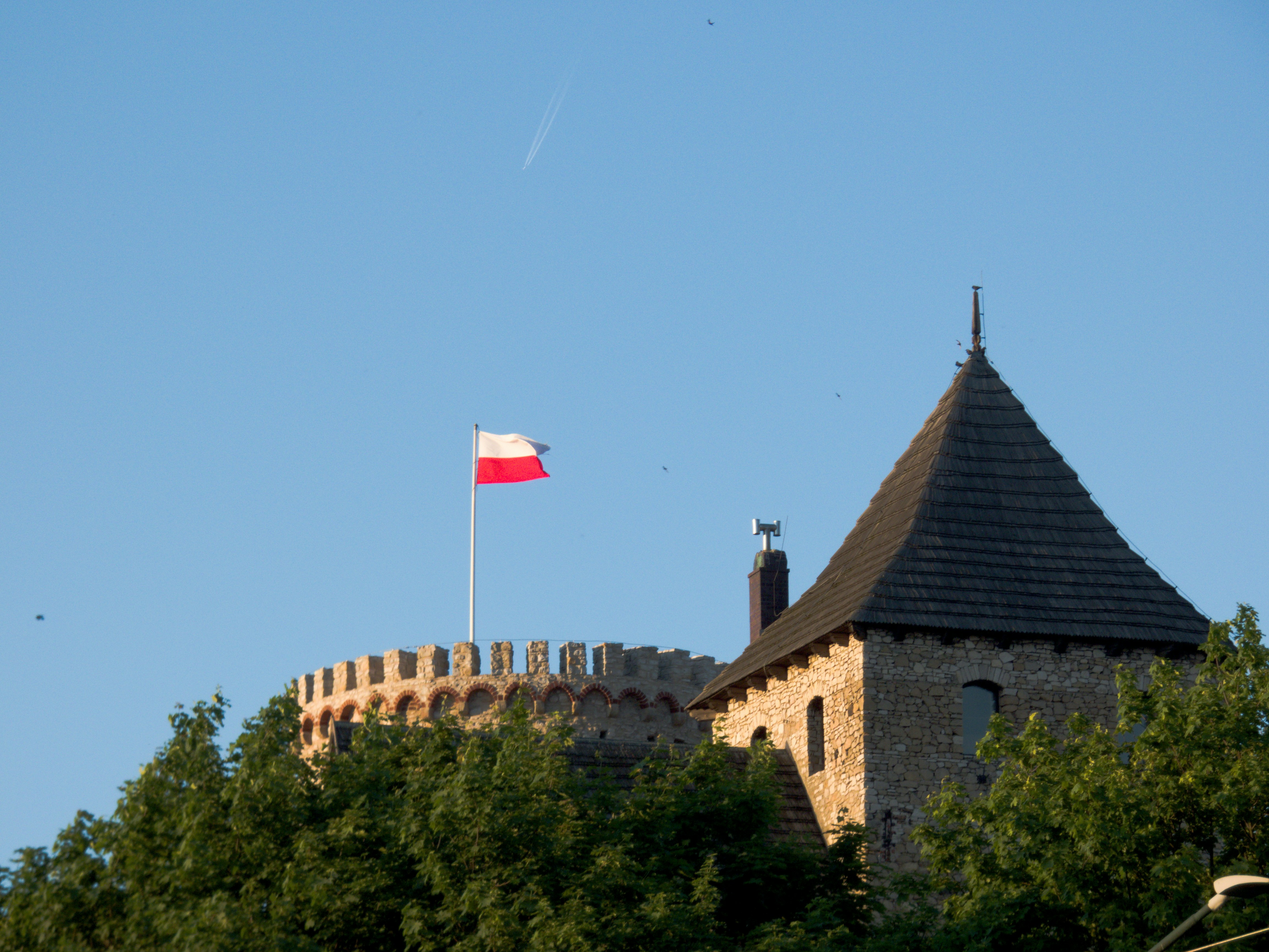 Flag over ancient fortress: sunlight on stone and slate