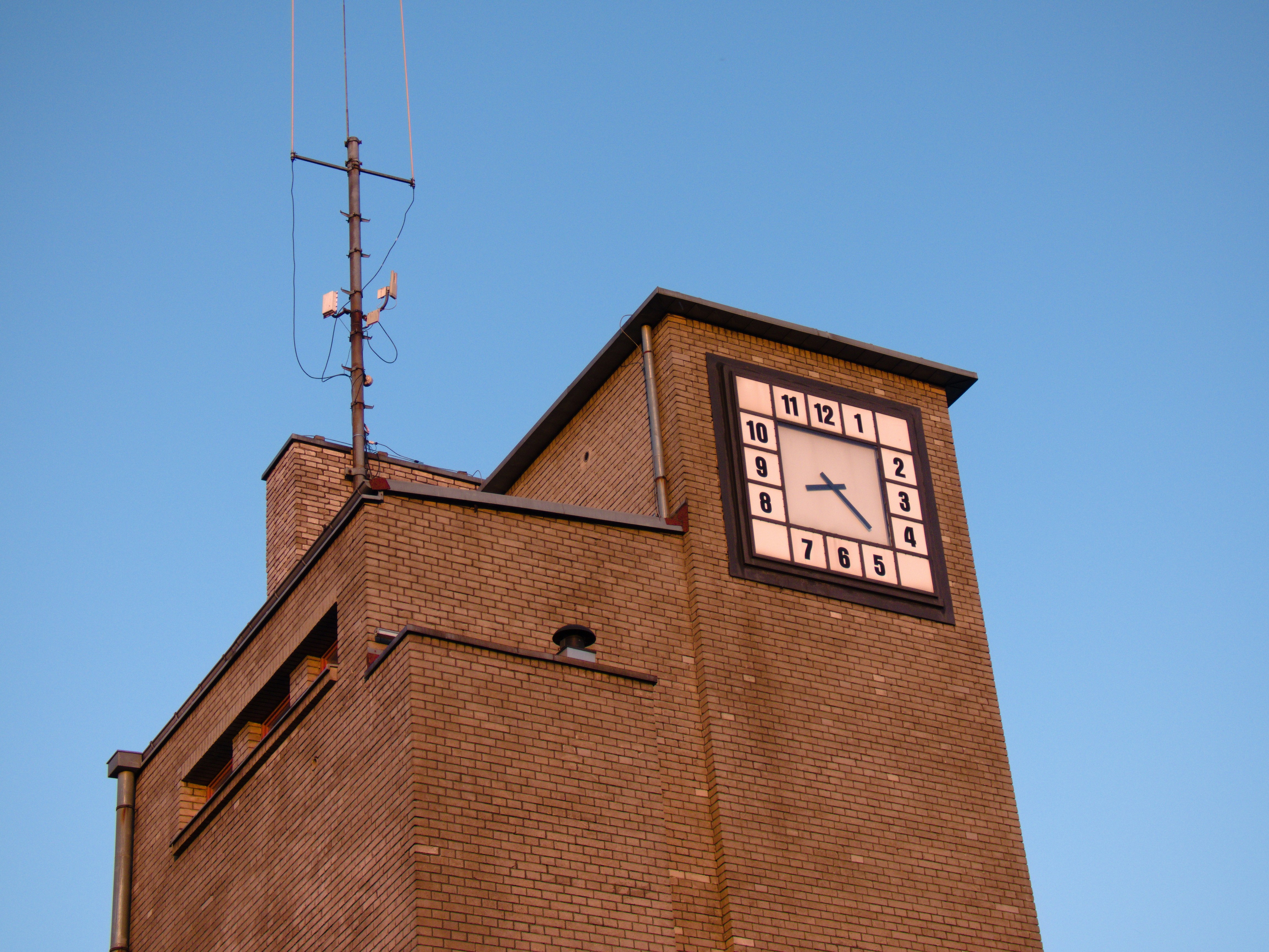 Brick Clock Tower Under a Clear Noon Sky