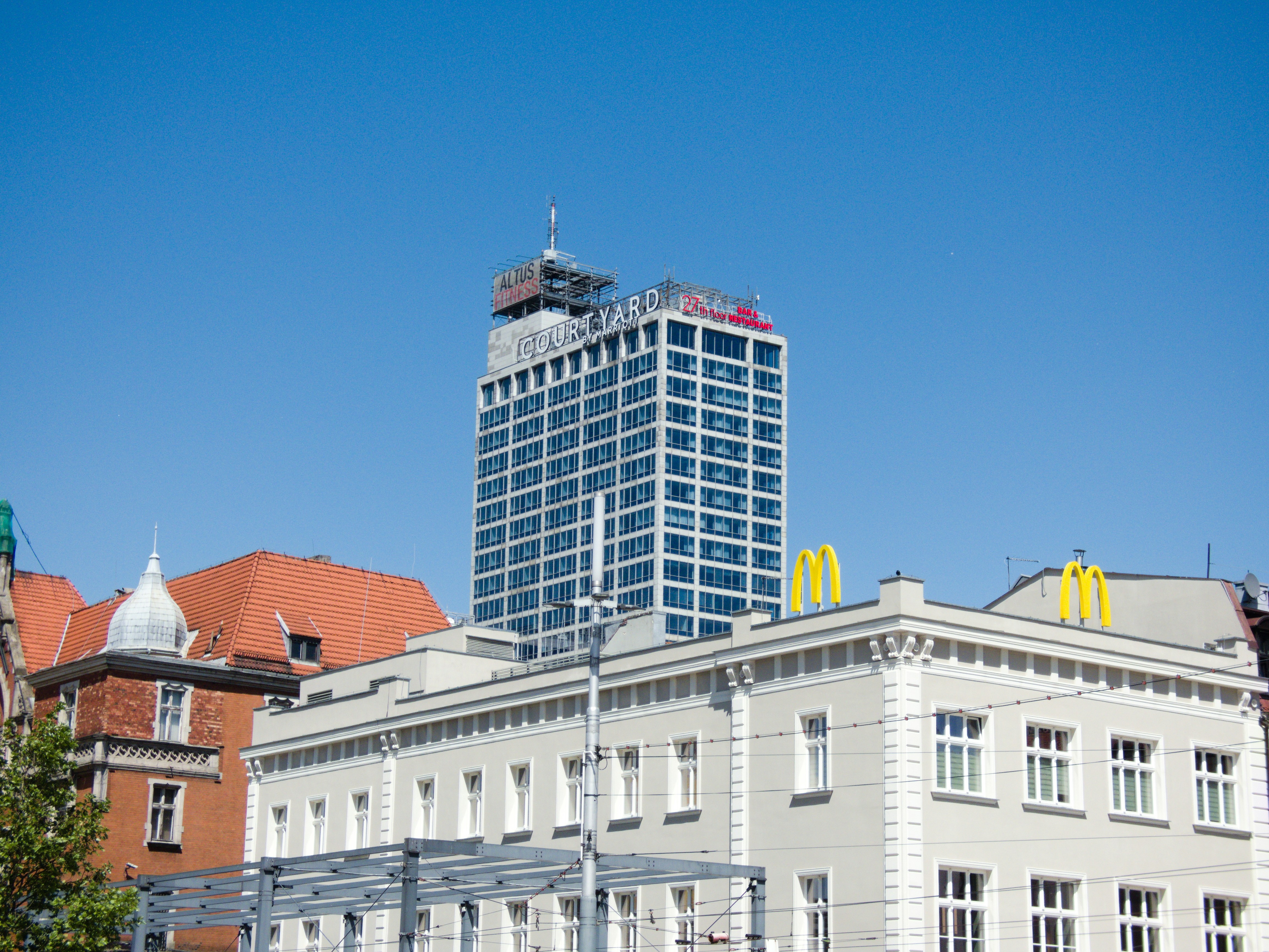 Skyline at Noon: Towering Signage Above a Classic European Street