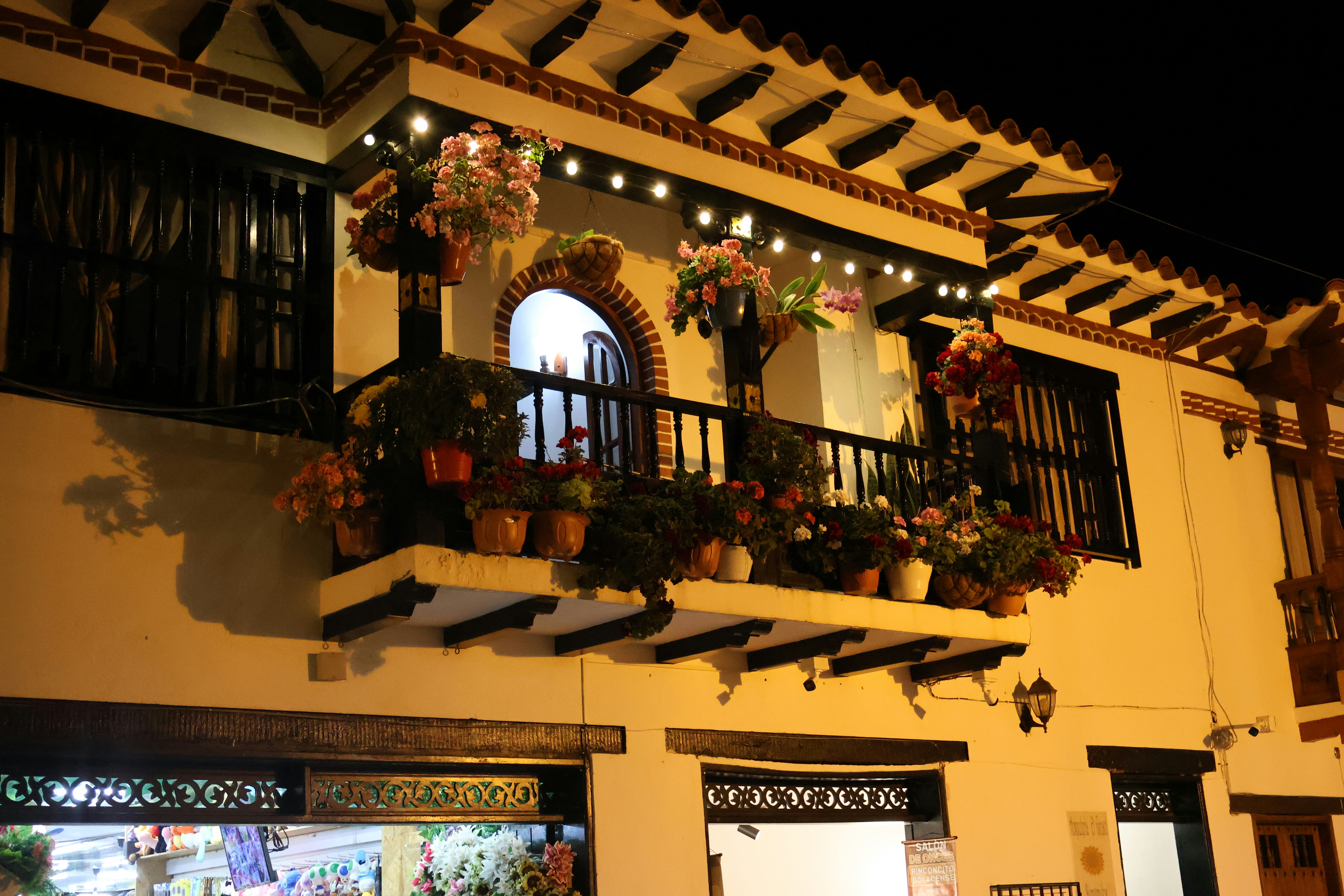 Night Balcony Bloom: Warm Lanterns Framing a Terracotta Balcony Garden