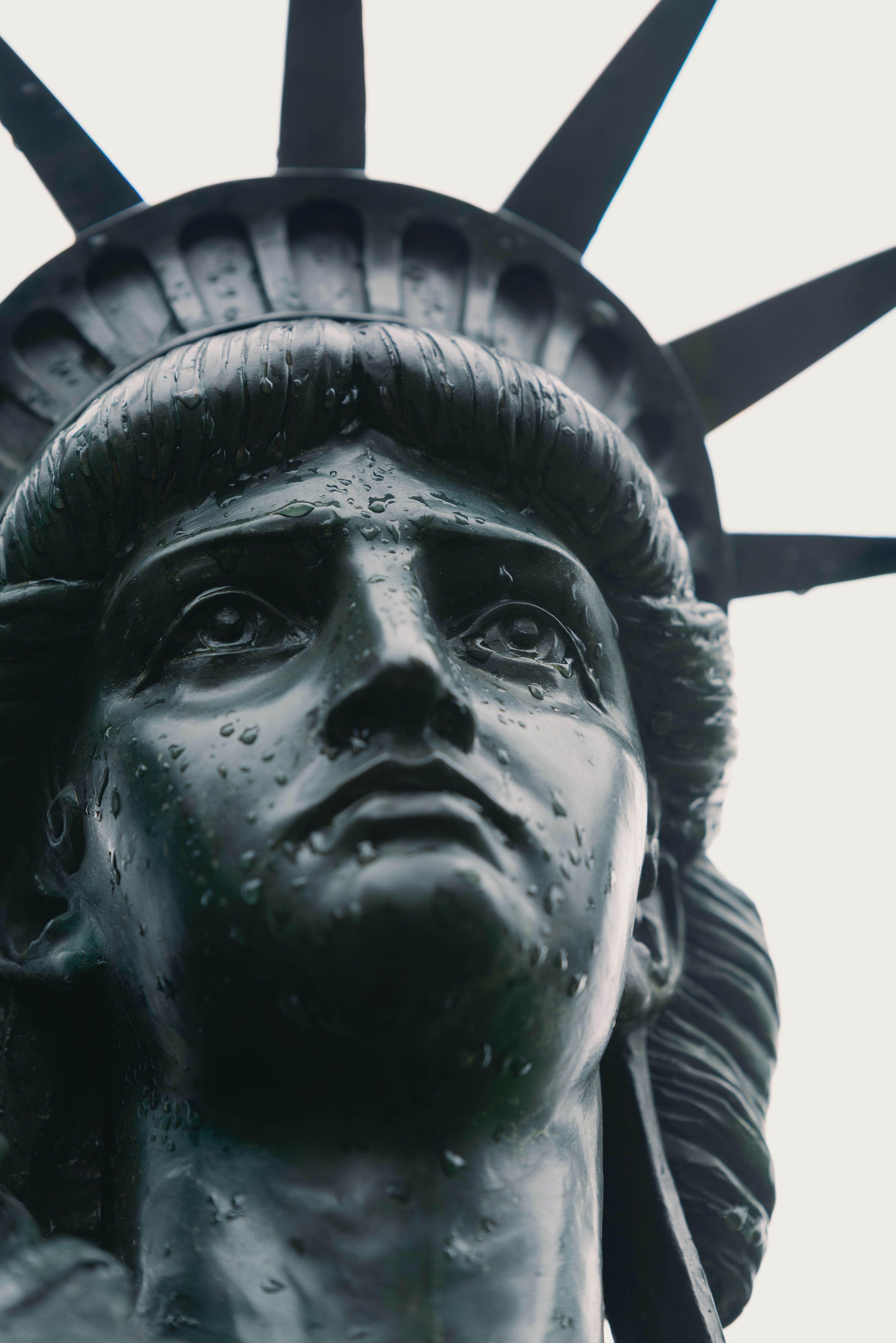 Gaze of Stone: A Raindrop-Streaked Statue Under Wide Spikes