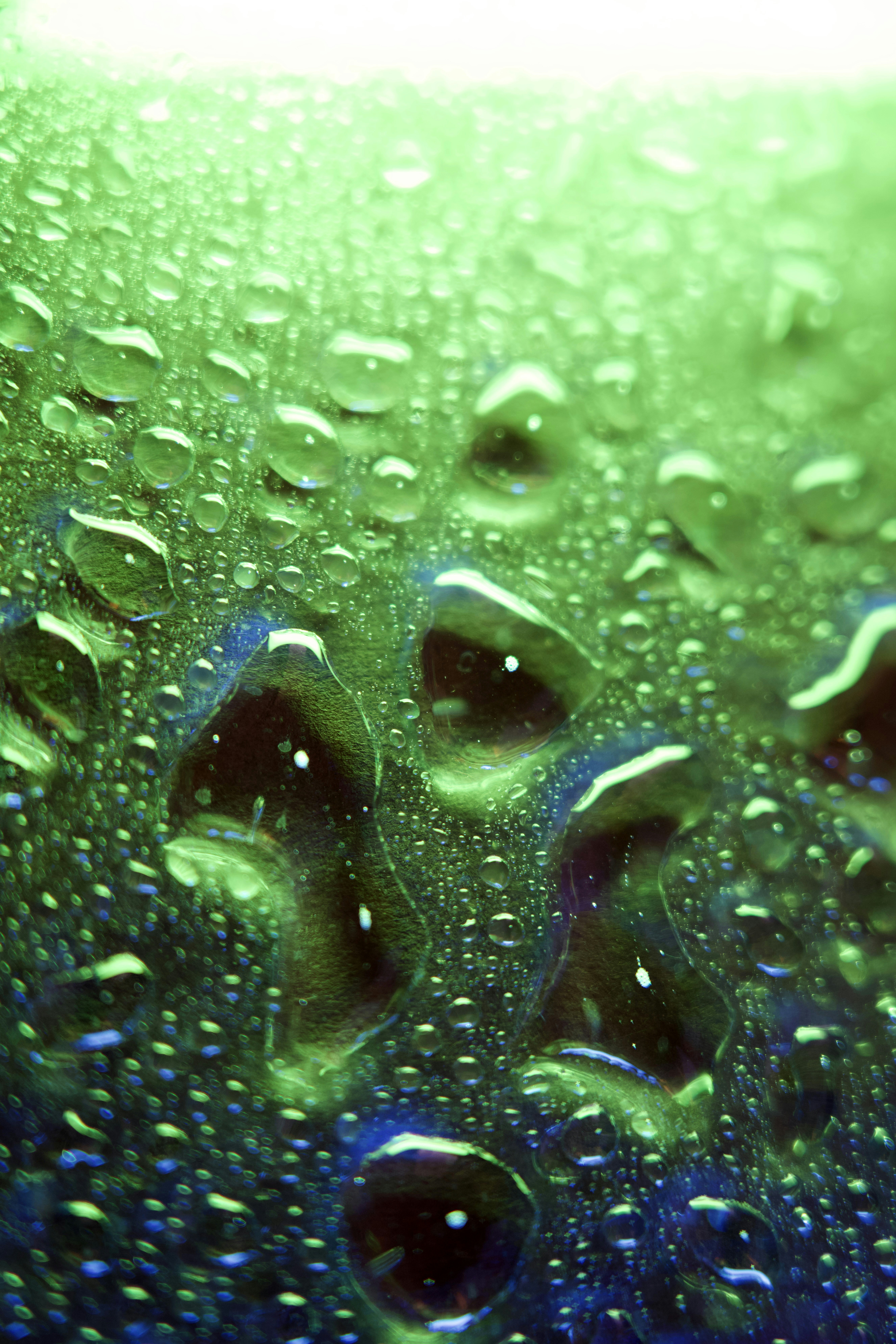 Liquid Mosaic: Green-Blue Droplets on Glass