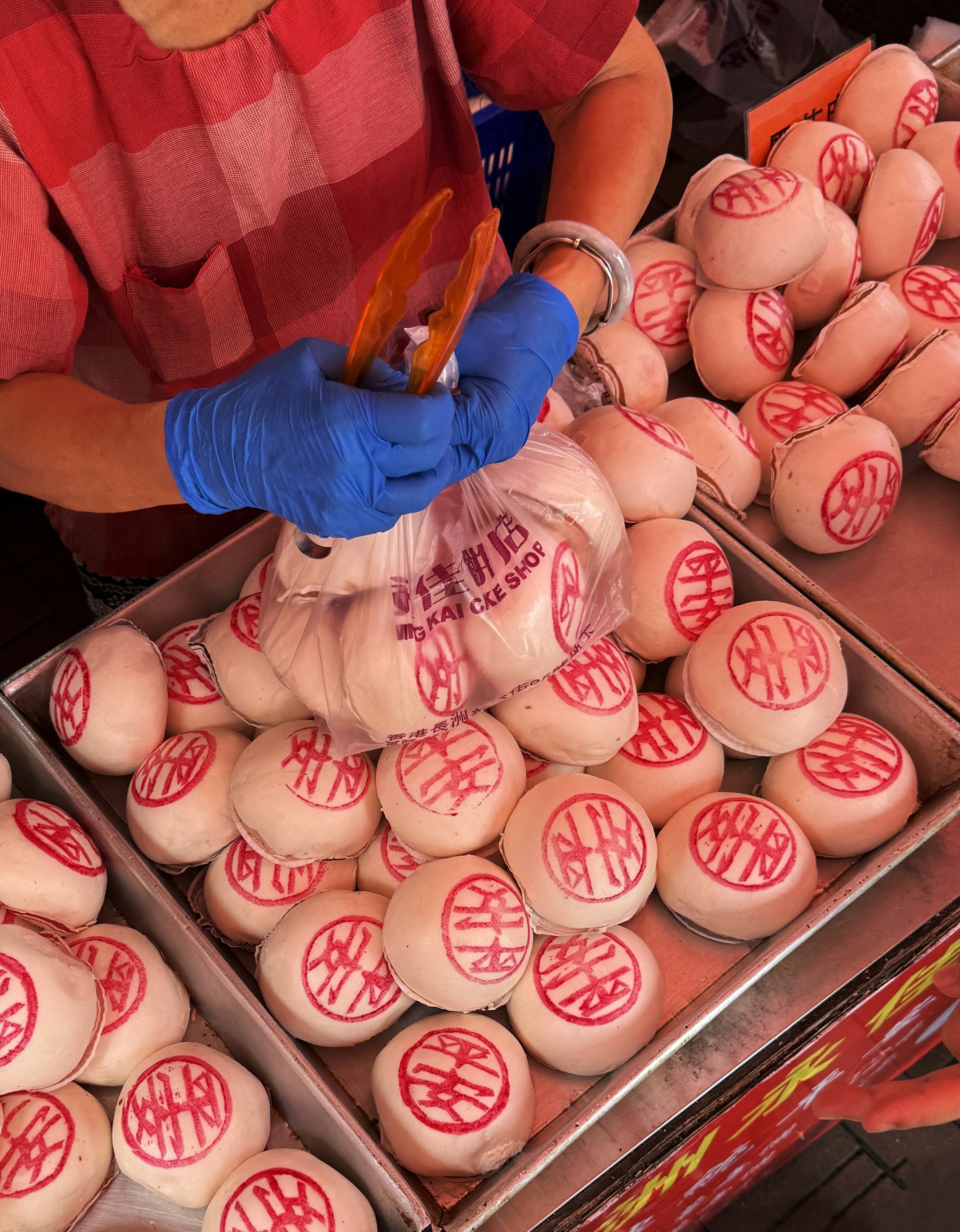 Gloved Hands Crafting Peeking Passages into Red-Stamped Steamed Buns