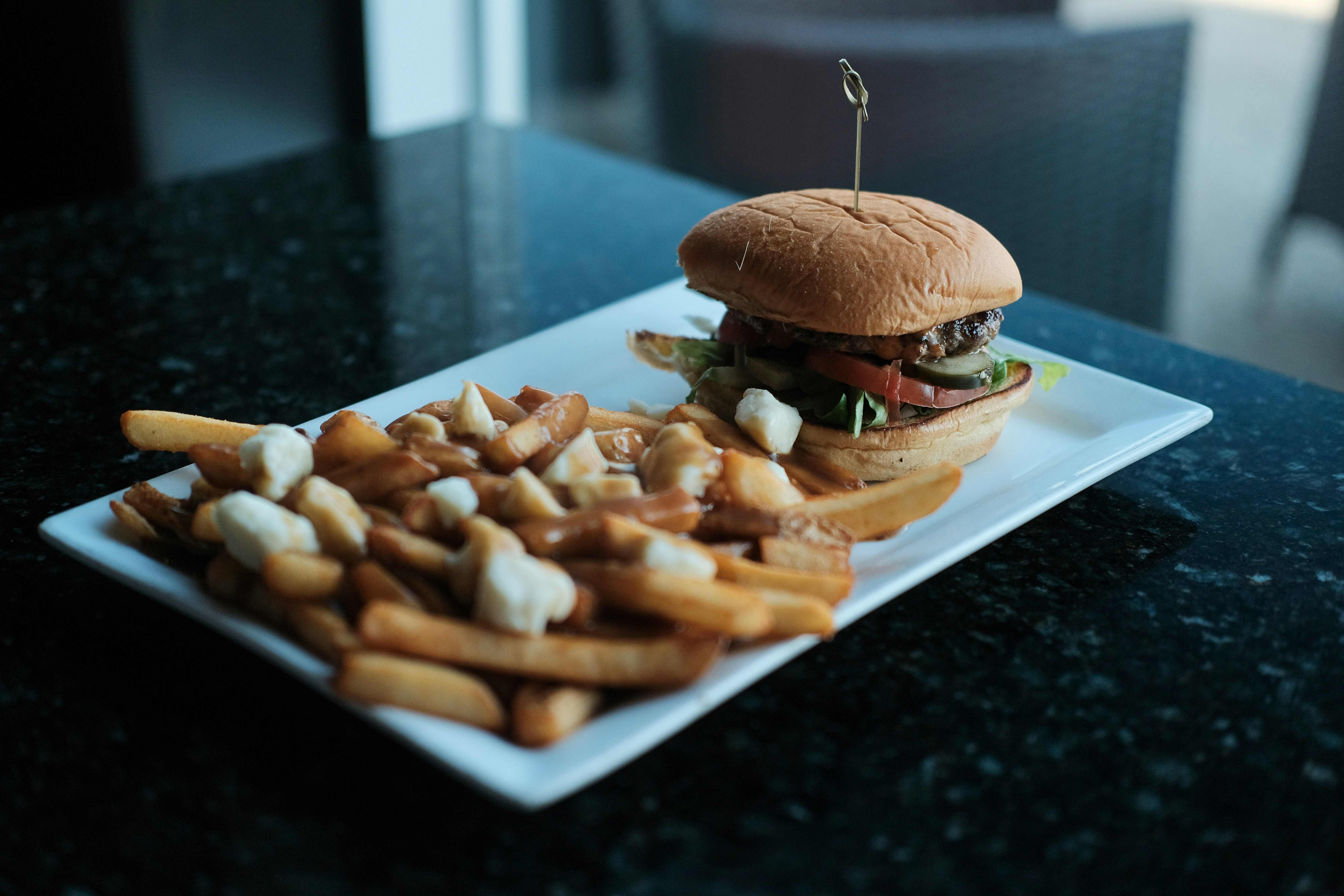 Tray of Golden Fries with a Gourmet Burger on a Marble Counter