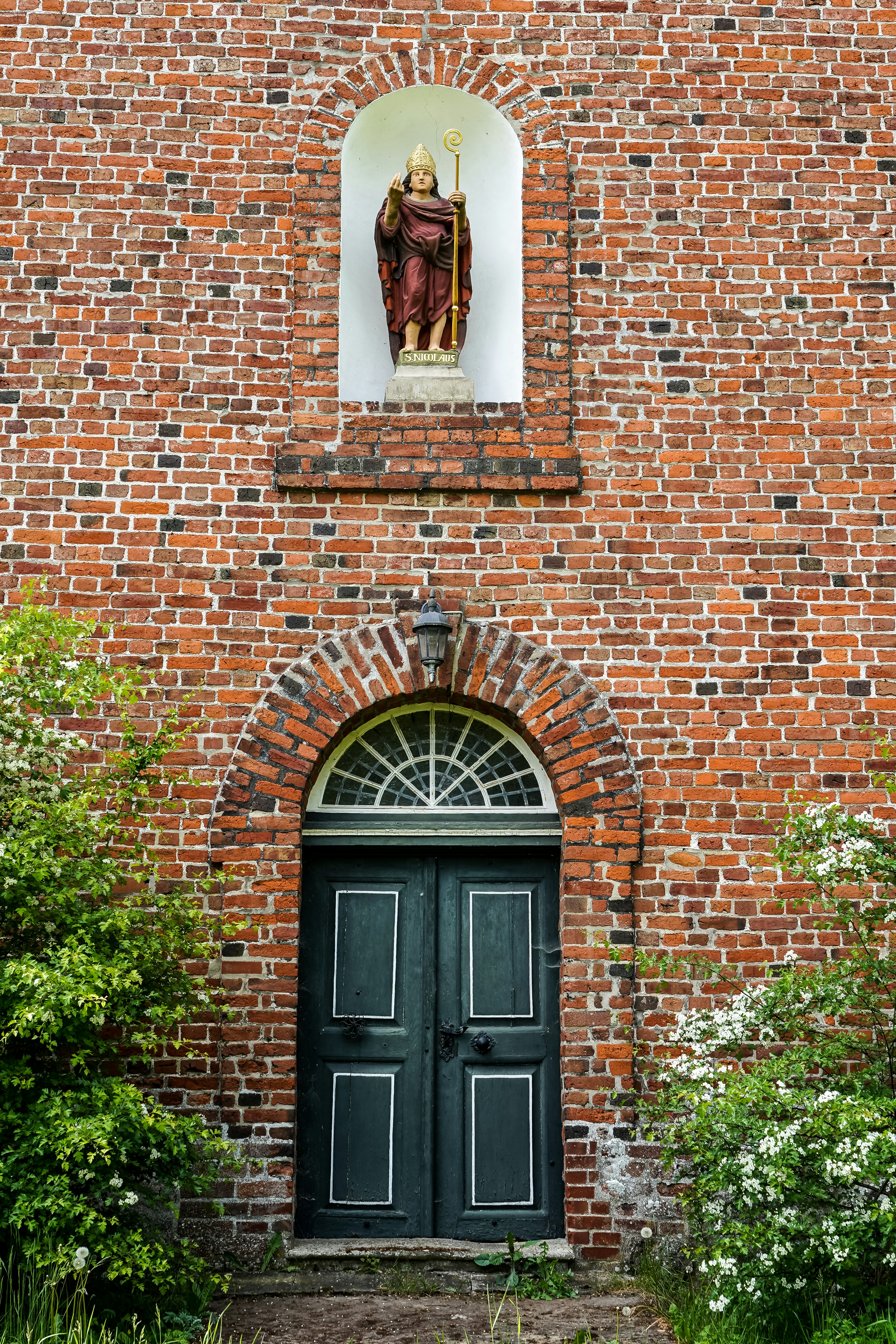 Statue in the Brick Niche Above the Dark Green Door