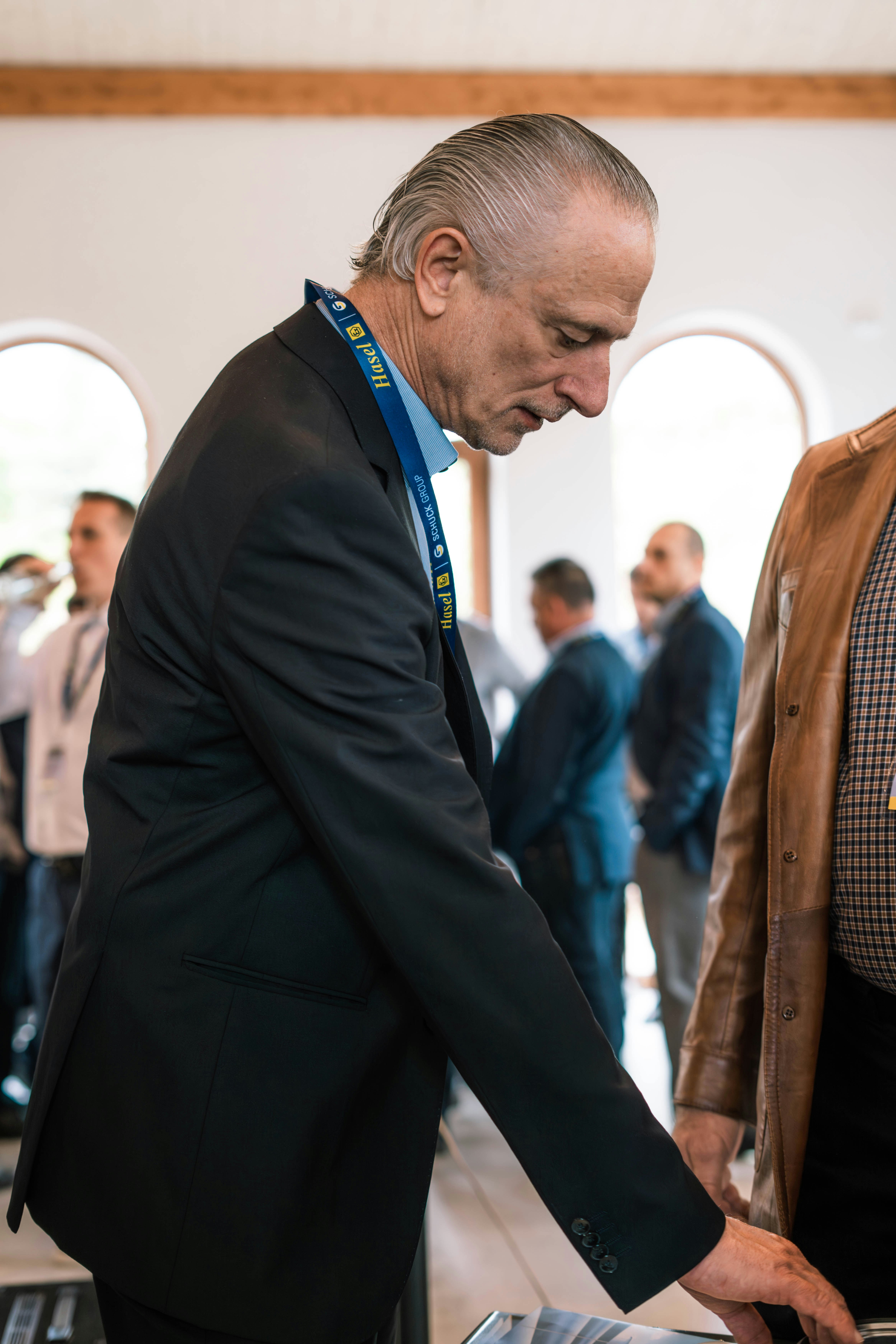 Quiet Focus: A man in a suit adjusts his coat at a conference