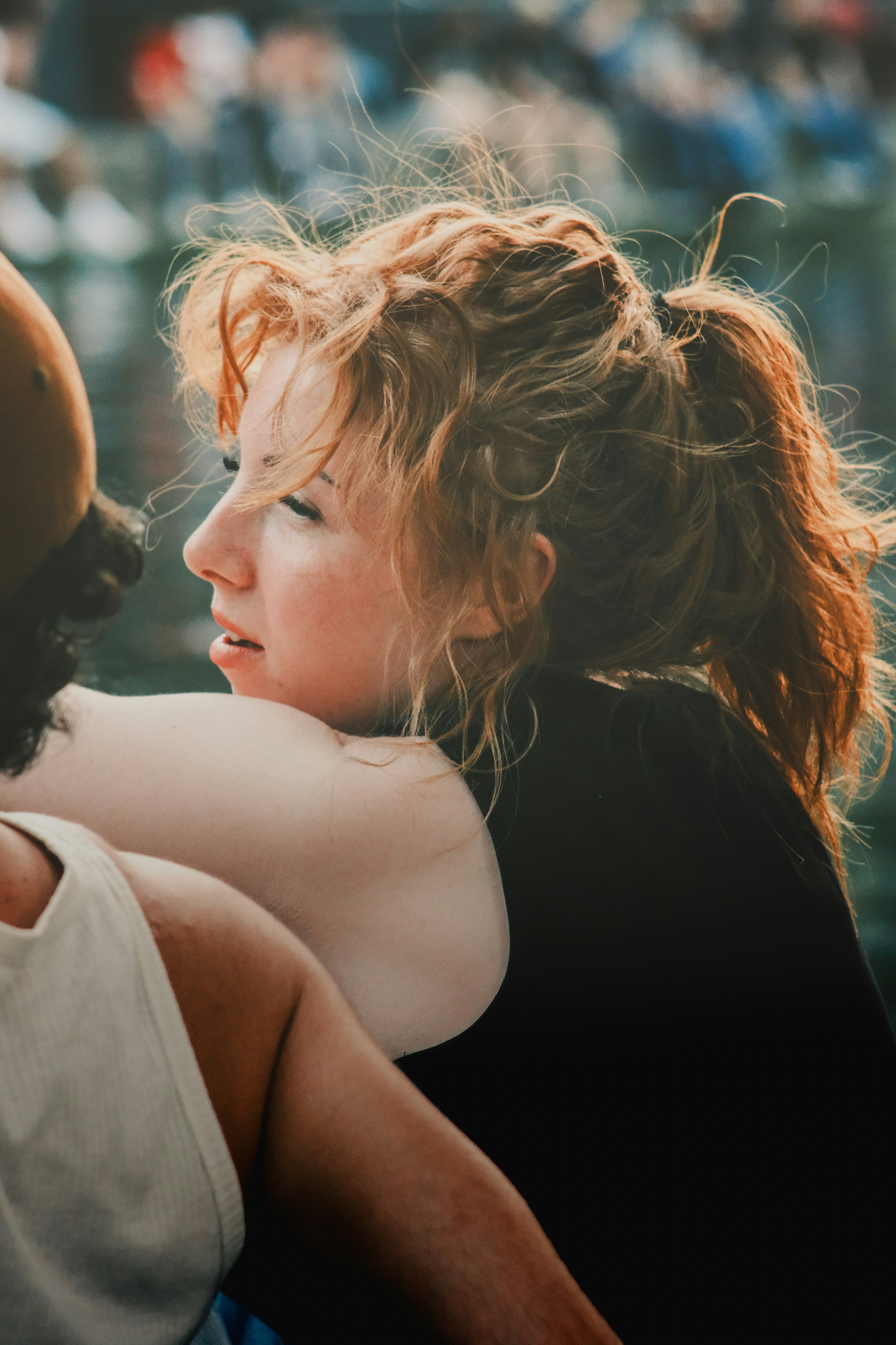 Young woman with red hair resting on a shoulder.