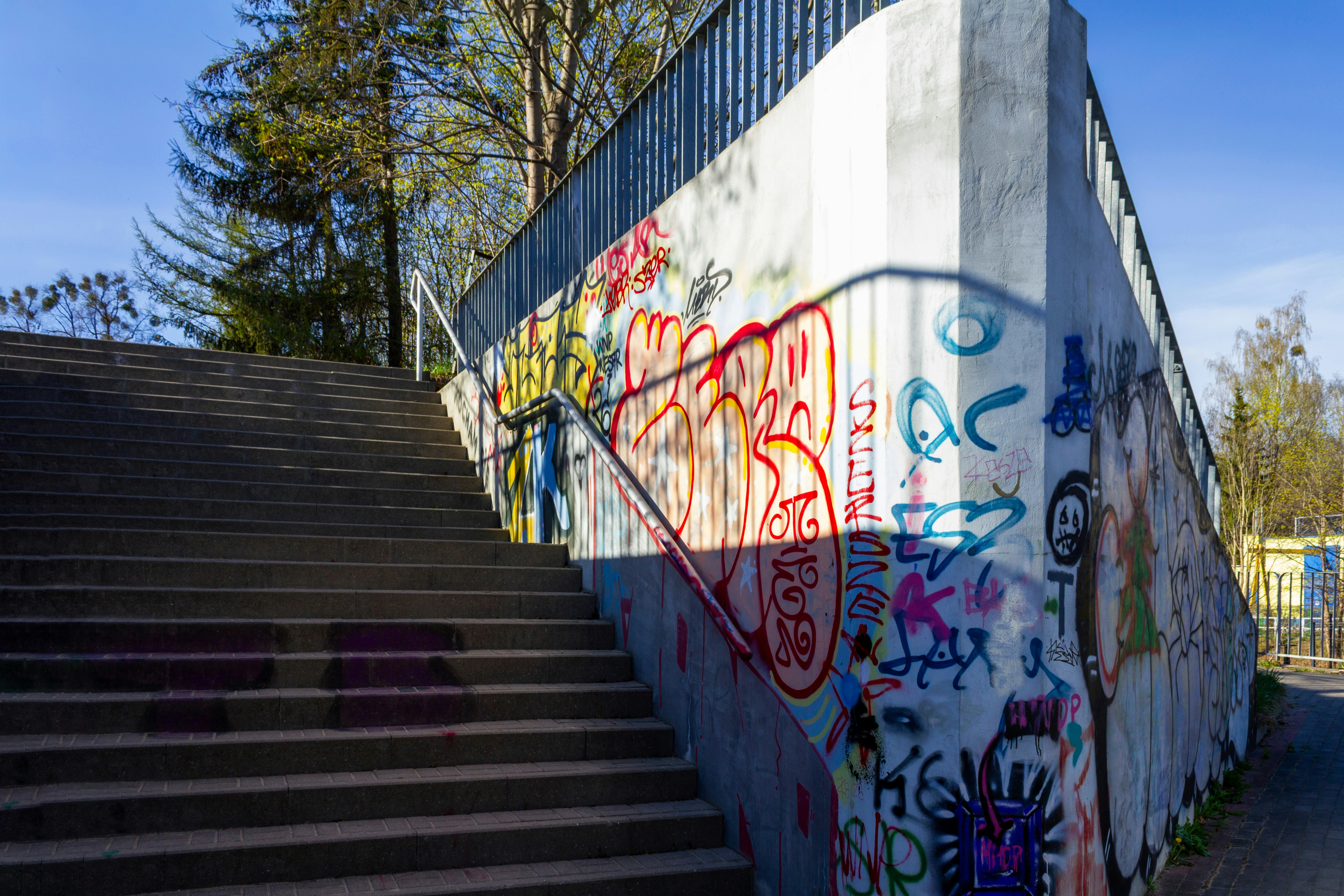 Graffiti Stairway: daylight bleed across a graffitied wall