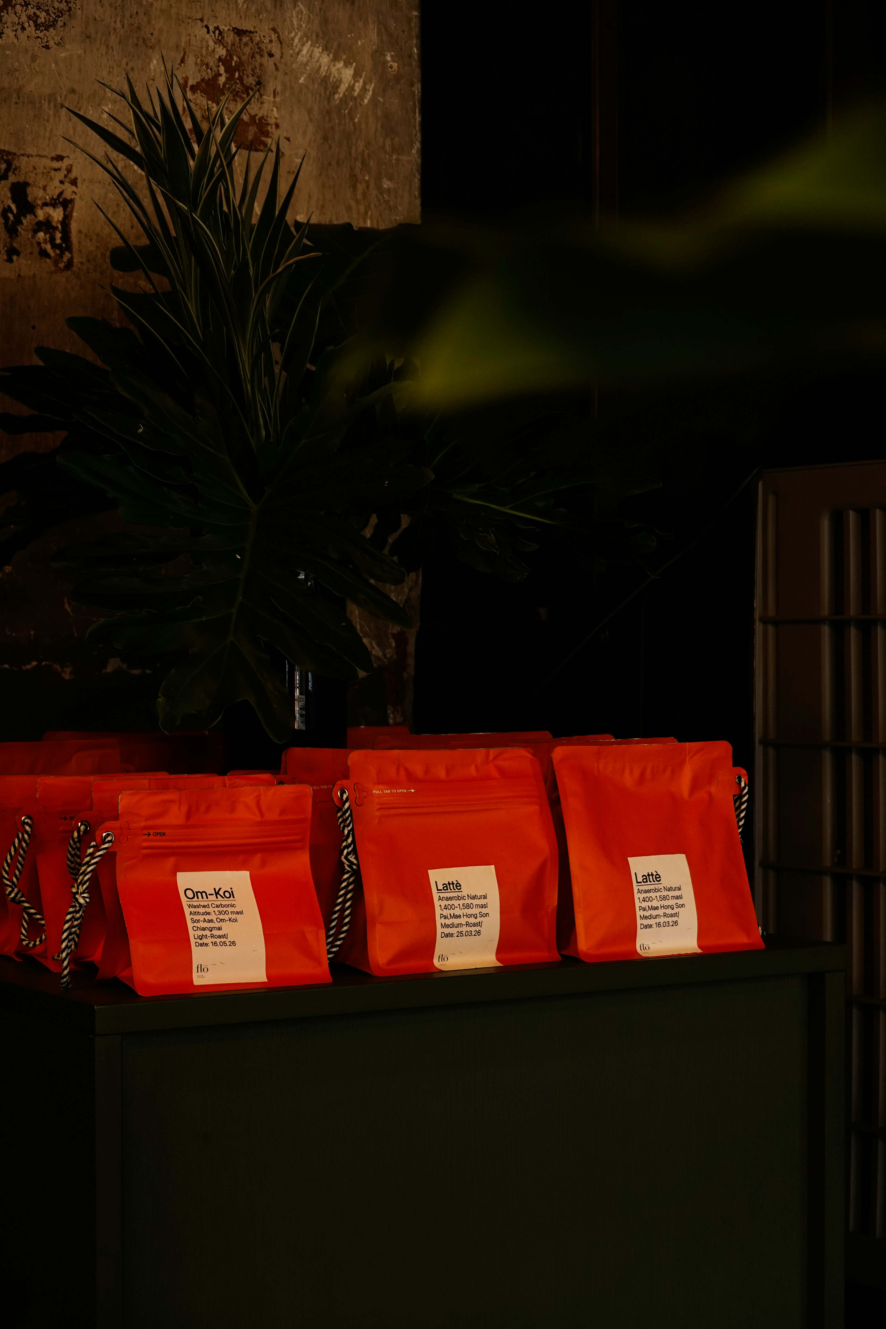 Rows of orange bags on a dark shelf under moody lighting