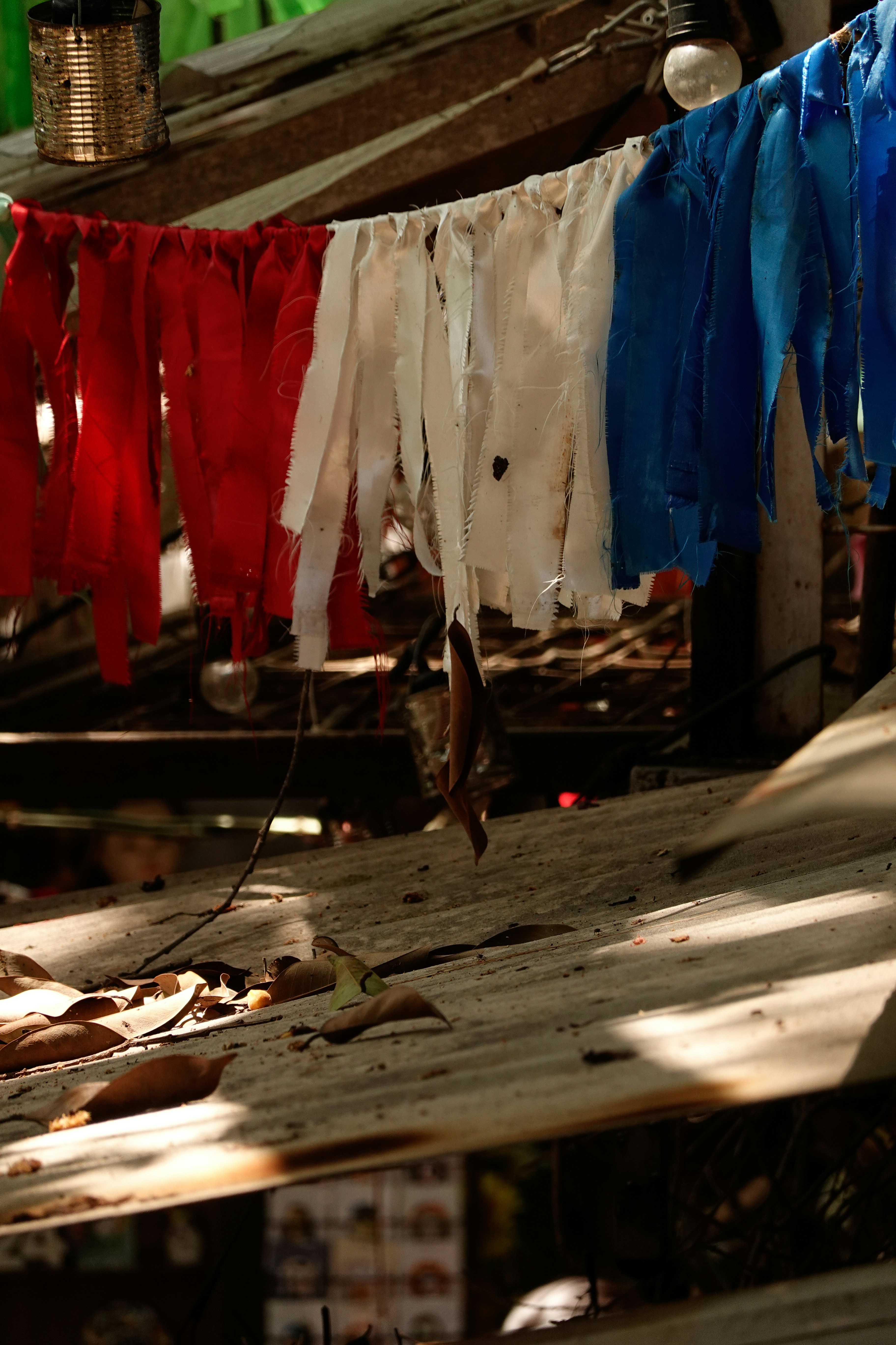 Colorful pennant garlands flutter in a sunlit outdoor stall