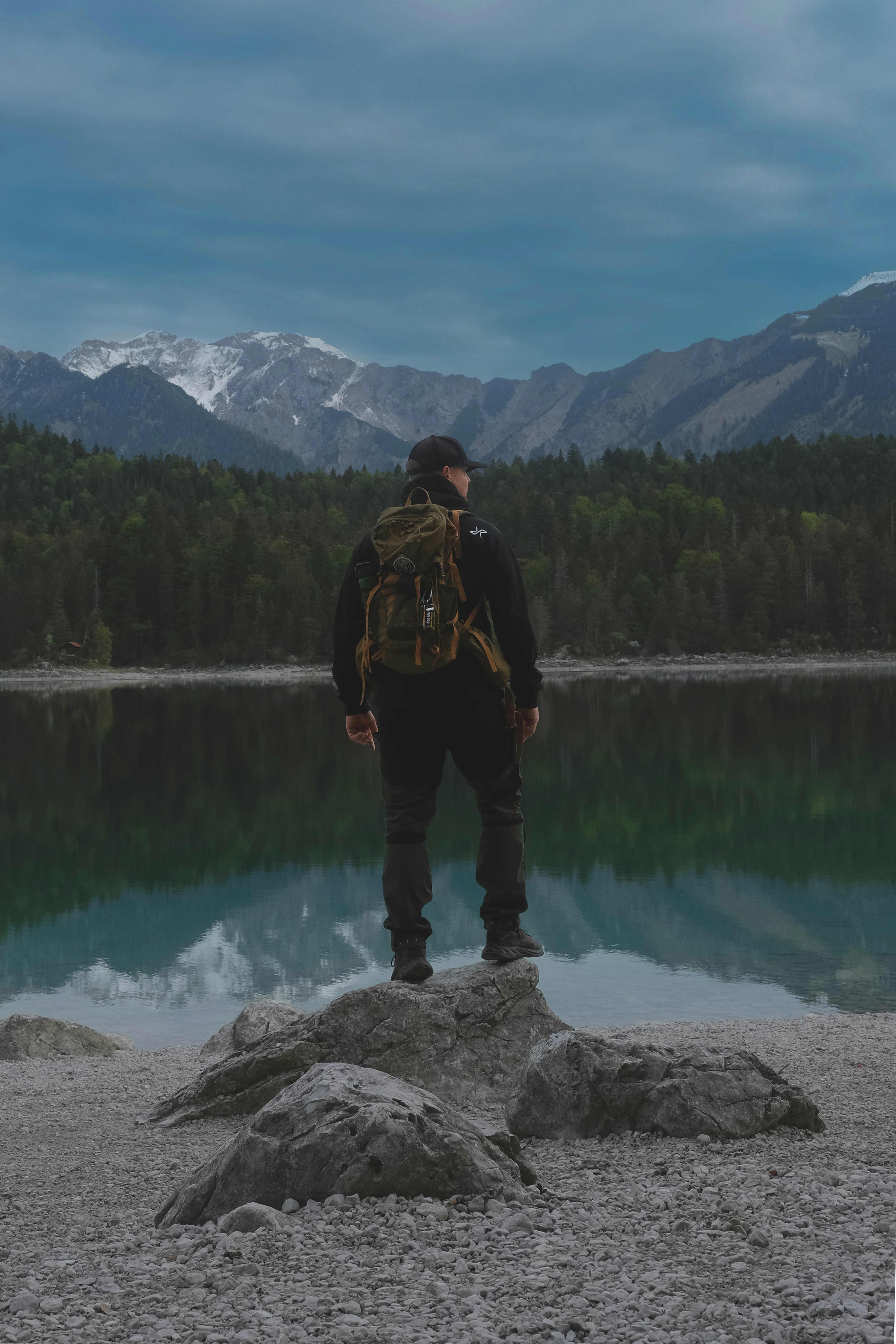 Hiker at the Edge: A Lone Figure Amid Mountain Mirror