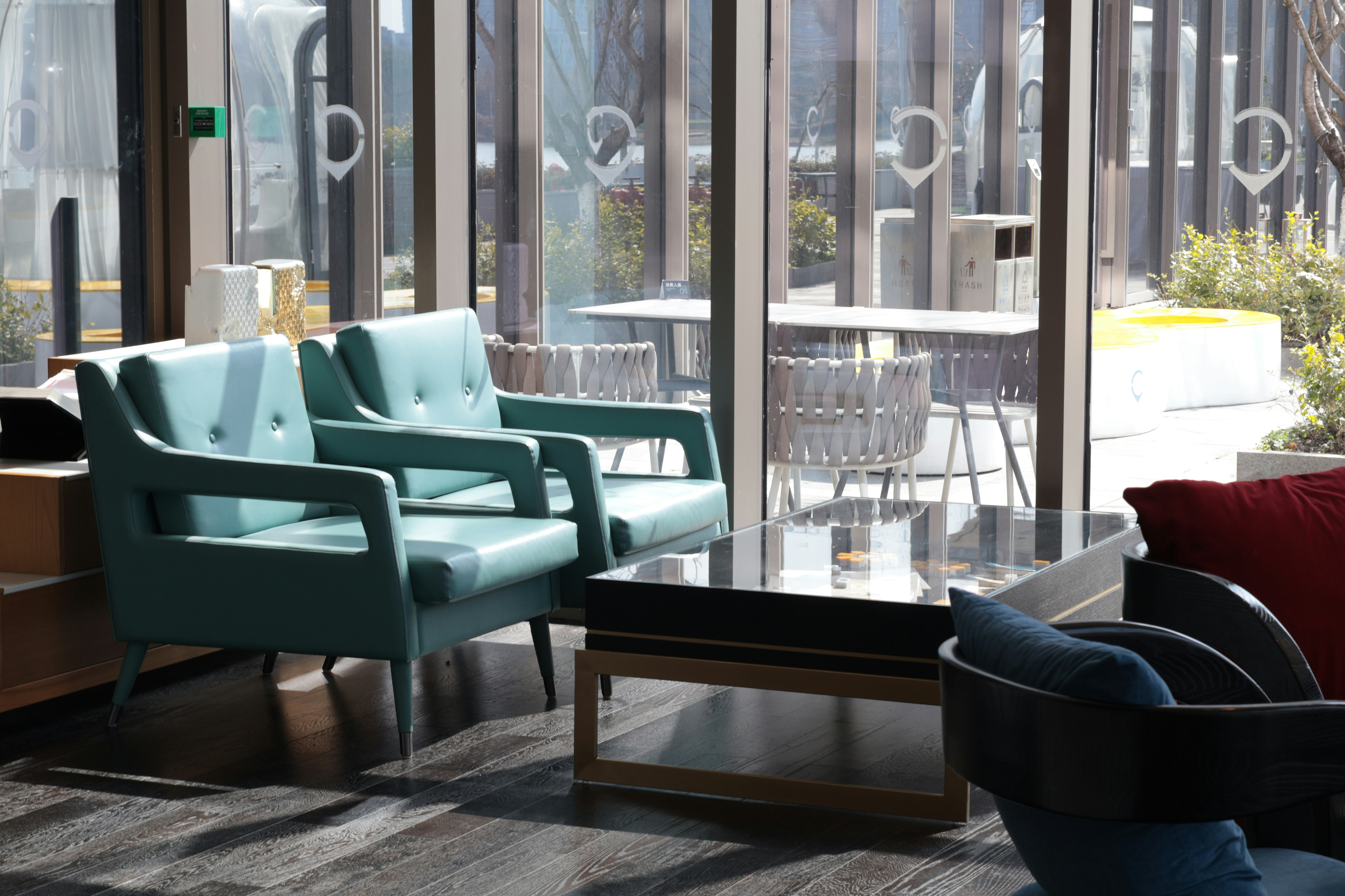 Two teal armchairs and coffee table in a modern lounge.
