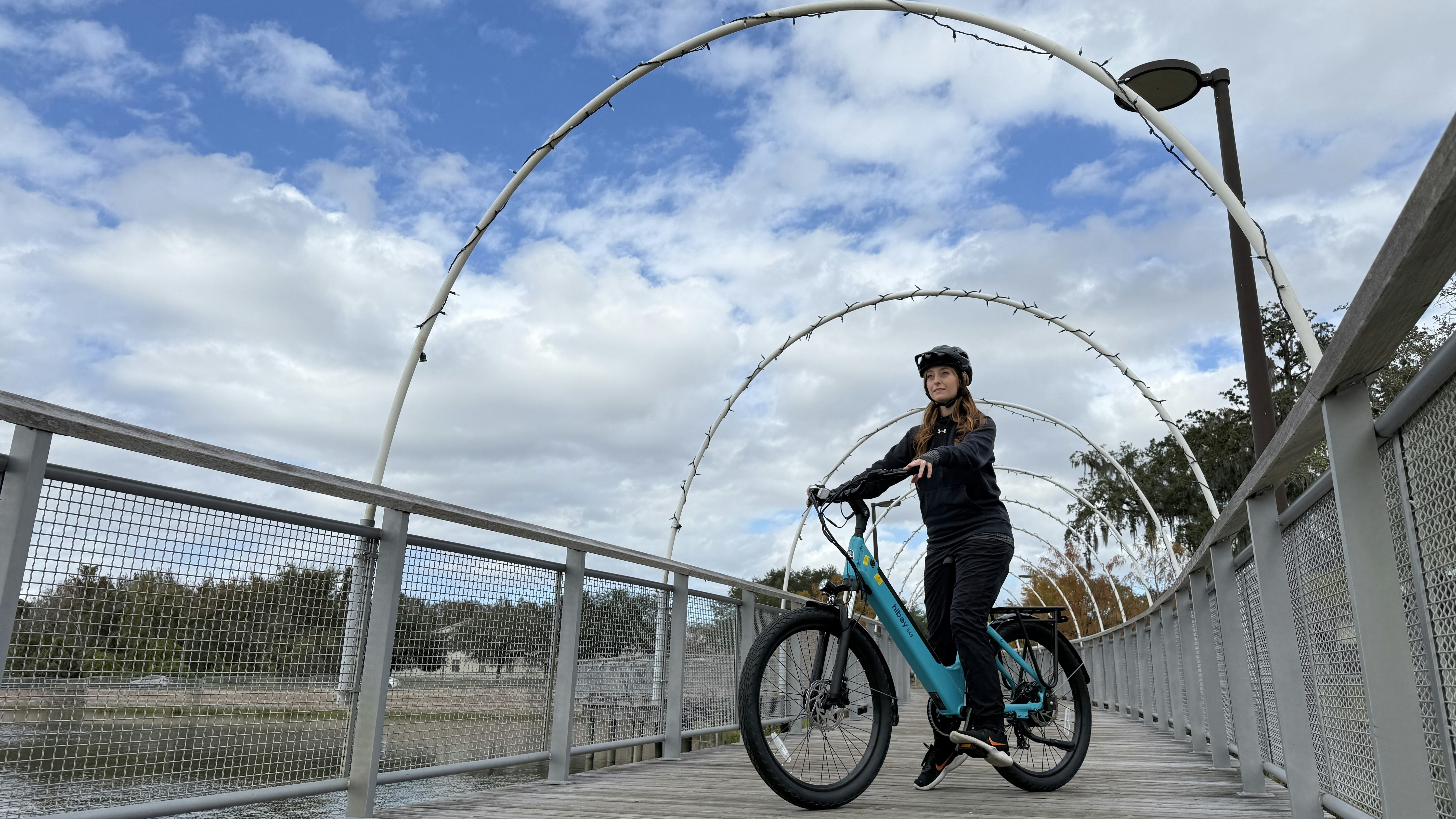 Cyclist on a curved-arch bridge: motion and balance in open sky